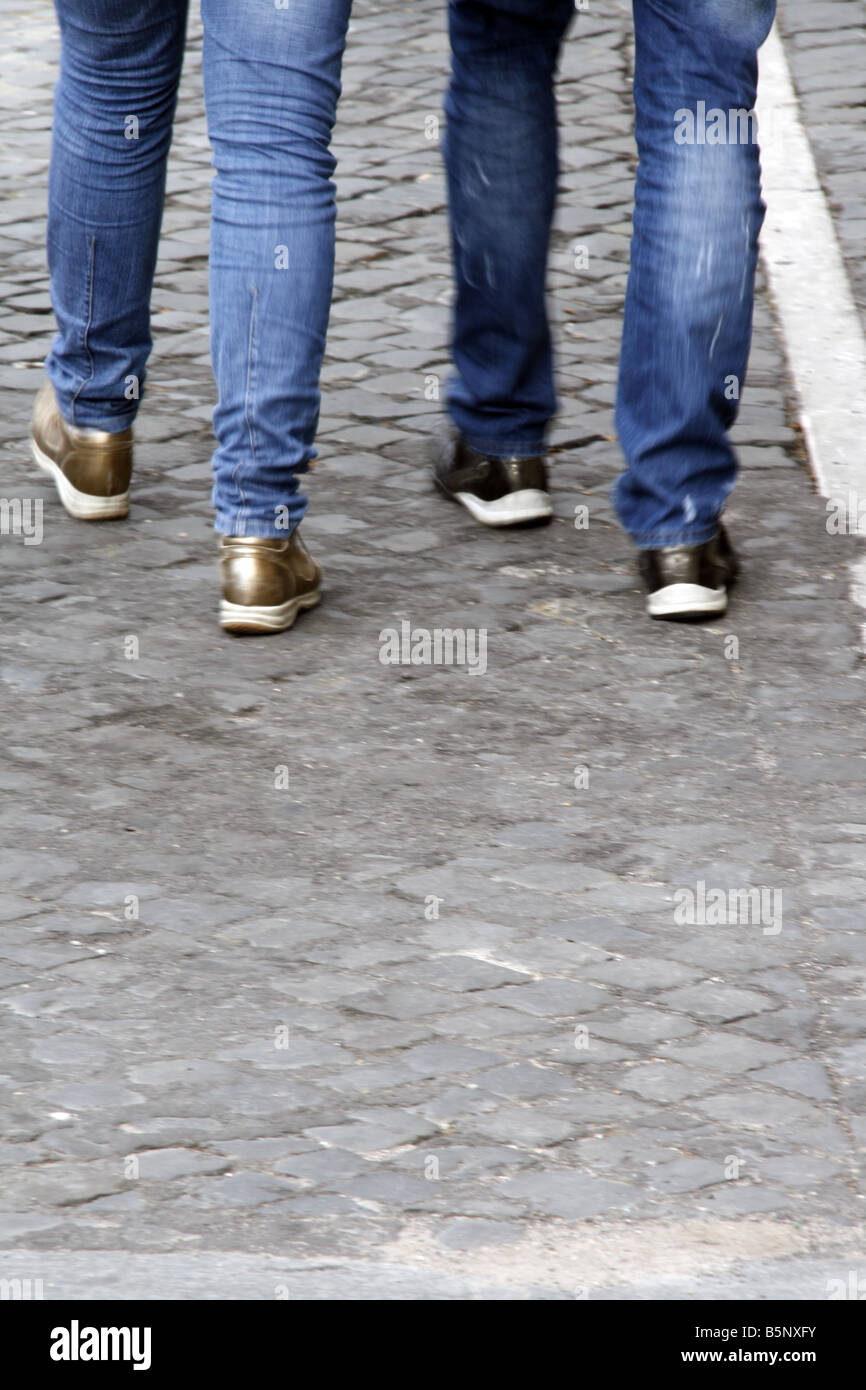 two people wearing jeans walking on street in town Stock Photo - Alamy