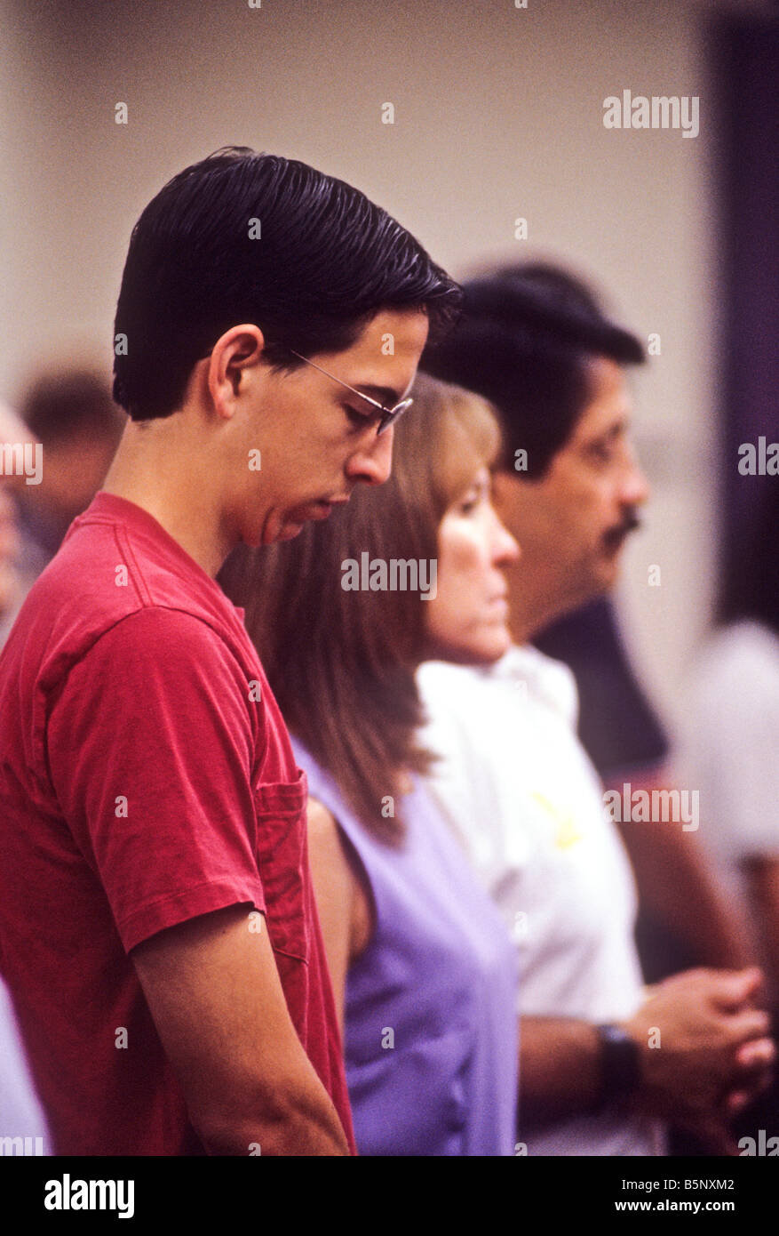Teen boy meditates during Catholic mass Stock Photo - Alamy