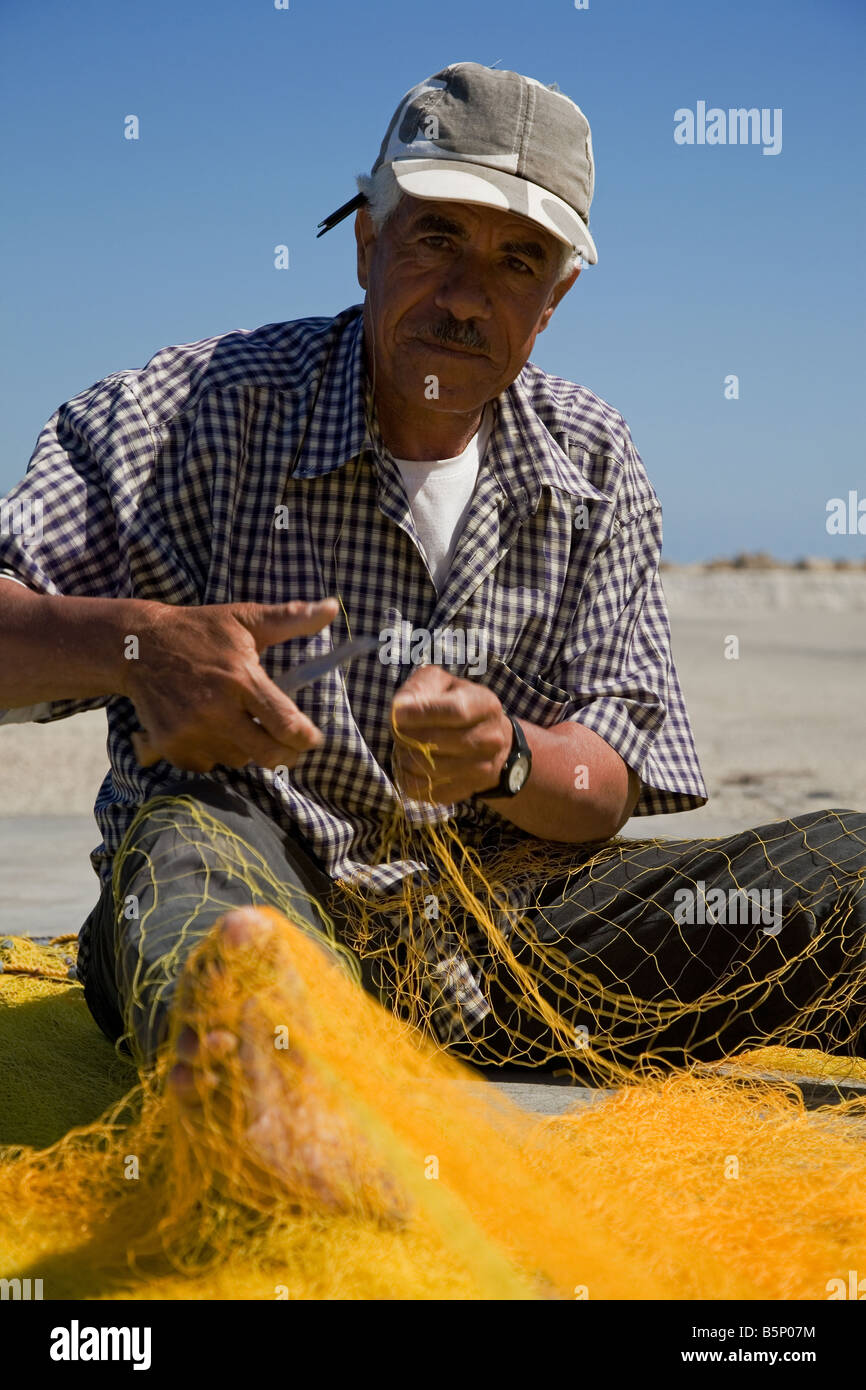 fisherman fixing fishing-net Stock Photo - Alamy