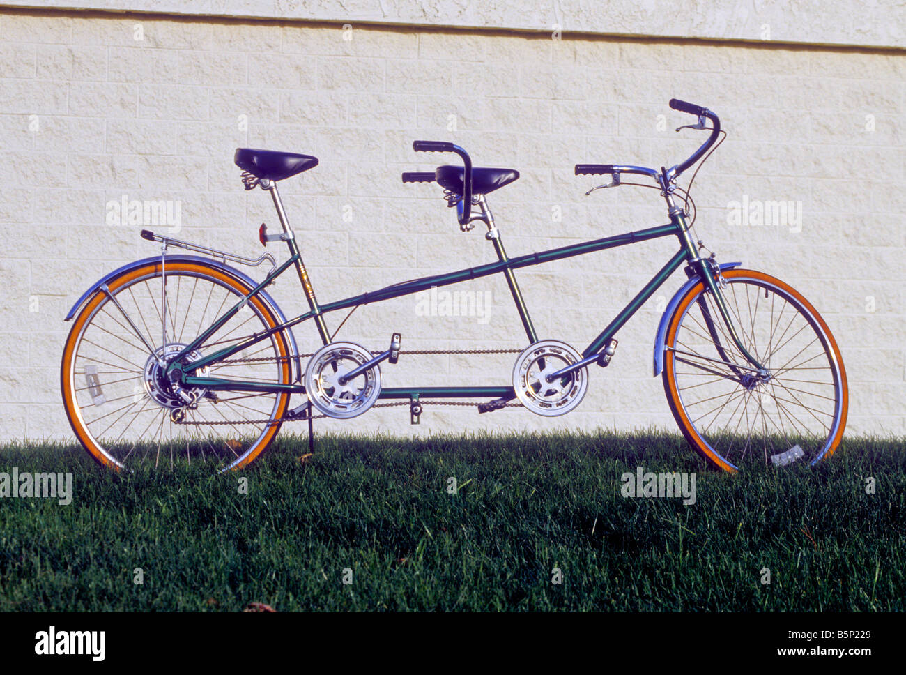 Tandem bicycle built for two leaning against wall outside Stock Photo ...