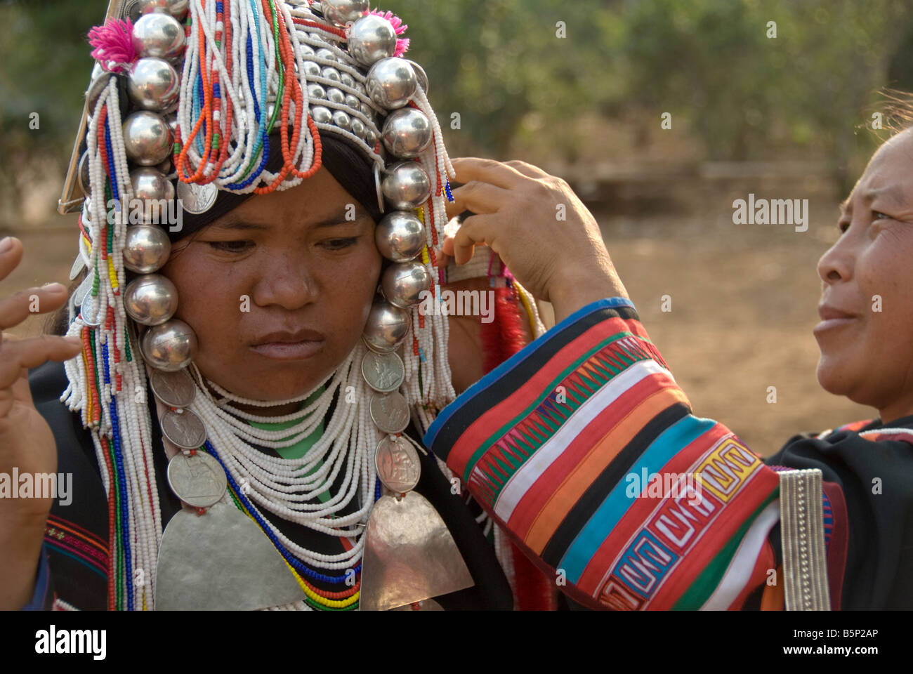 Akha hill tribe woman getting dressed in her traditional costume in a ...