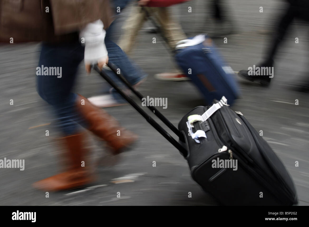 young people pulling trolley luggage cases in town Stock Photo - Alamy