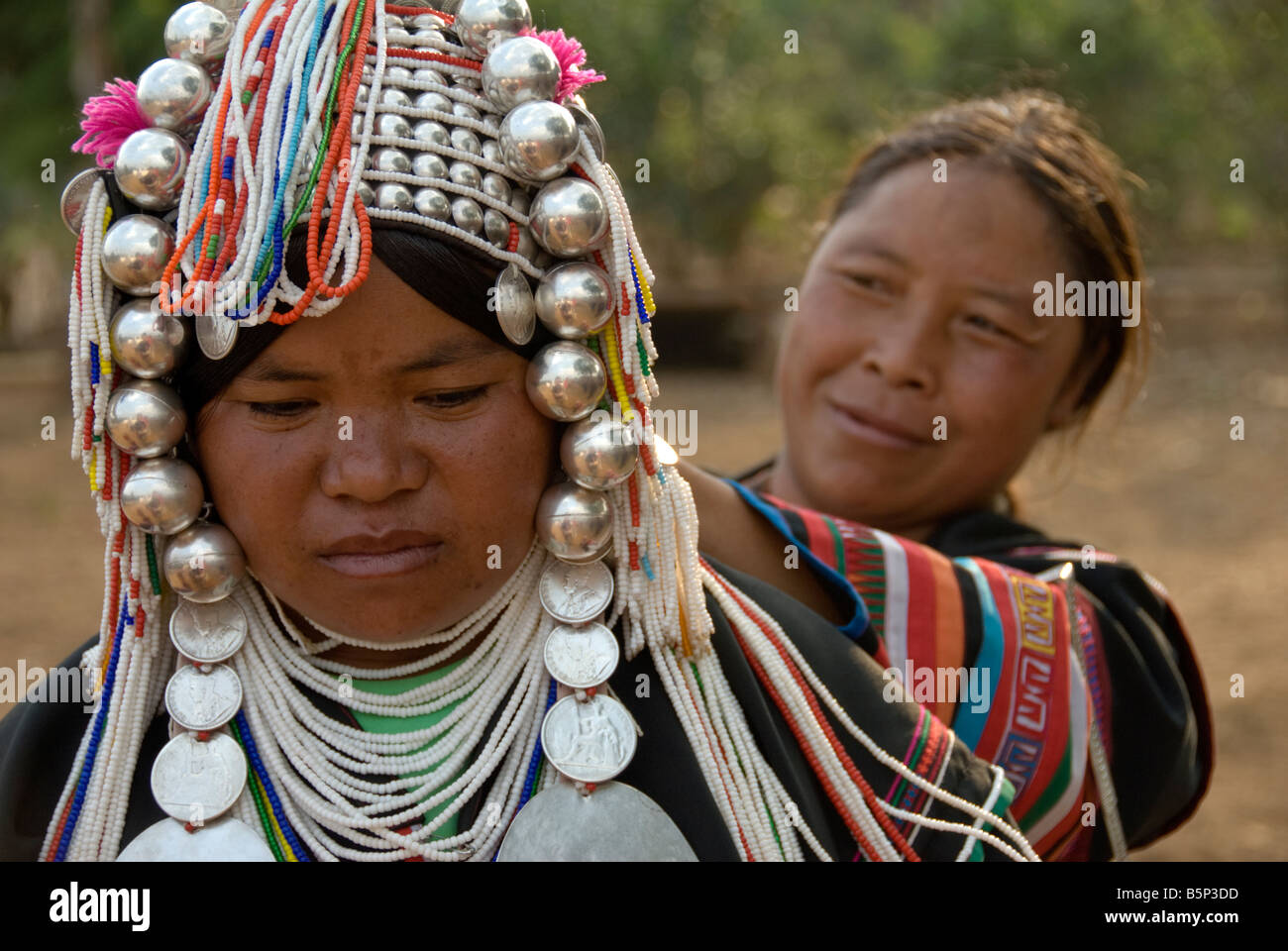 Akha hill tribe woman getting dressed in her traditional costume in a ...