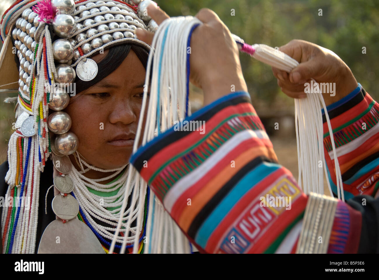 Akha hill tribe woman getting dressed in her traditional costume in a ...