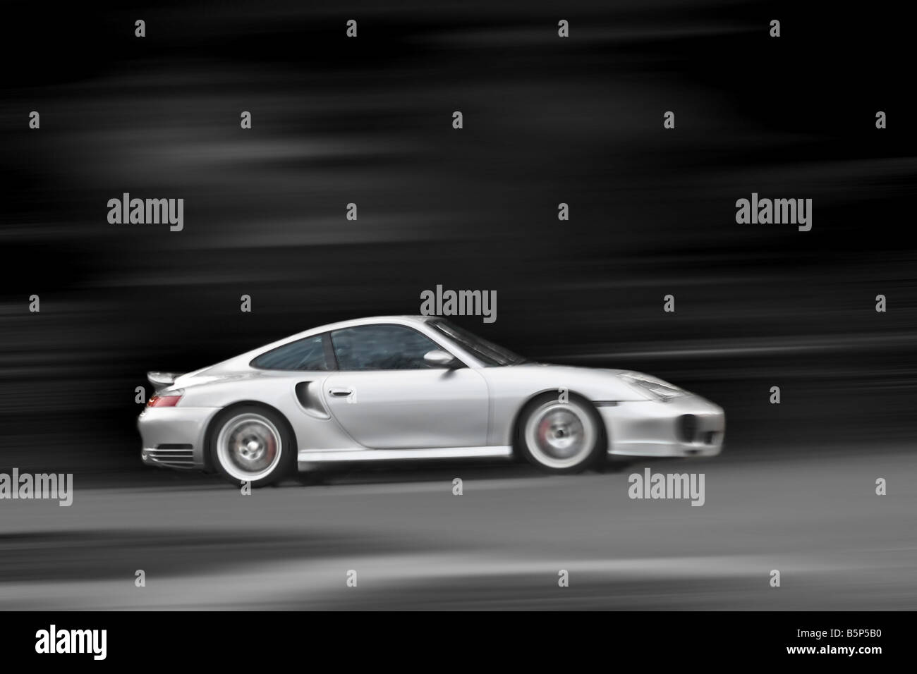 A modern sports car speeding along the road with a motion blur effect ...