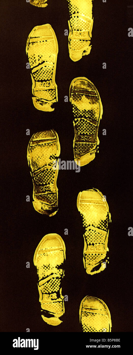 Yellow shoeprints on black background Stock Photo - Alamy