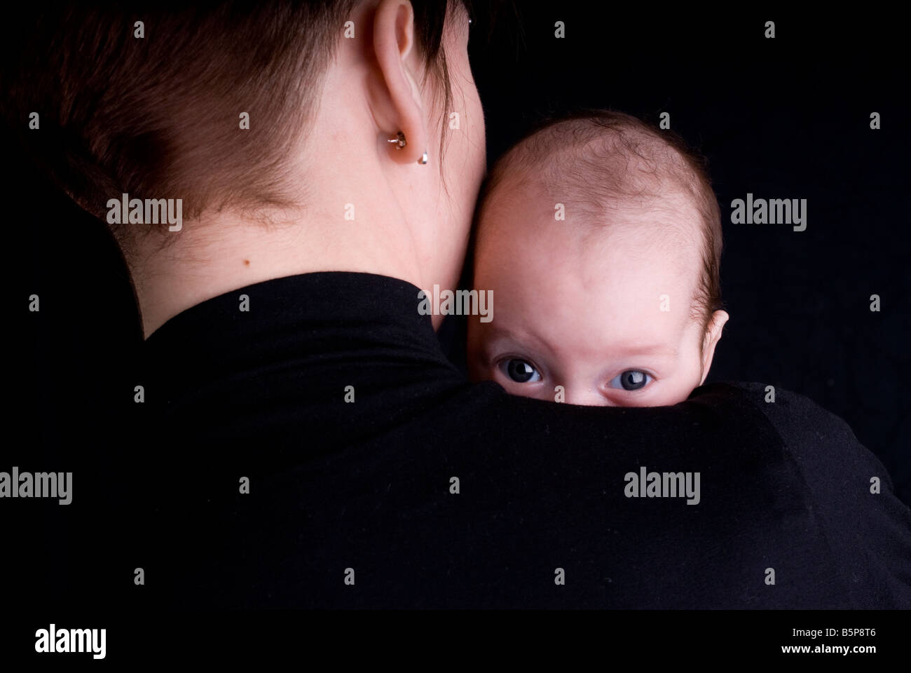 Baby looking over mother's shoulders Stock Photo - Alamy