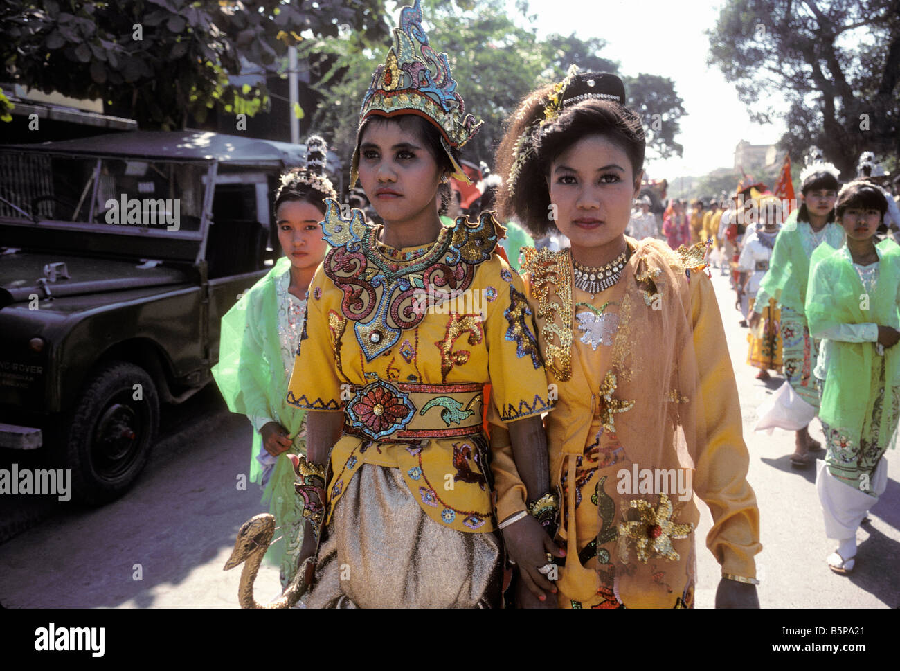 Burmese walk in a procession wearing traditional costumes in Rangoon or ...