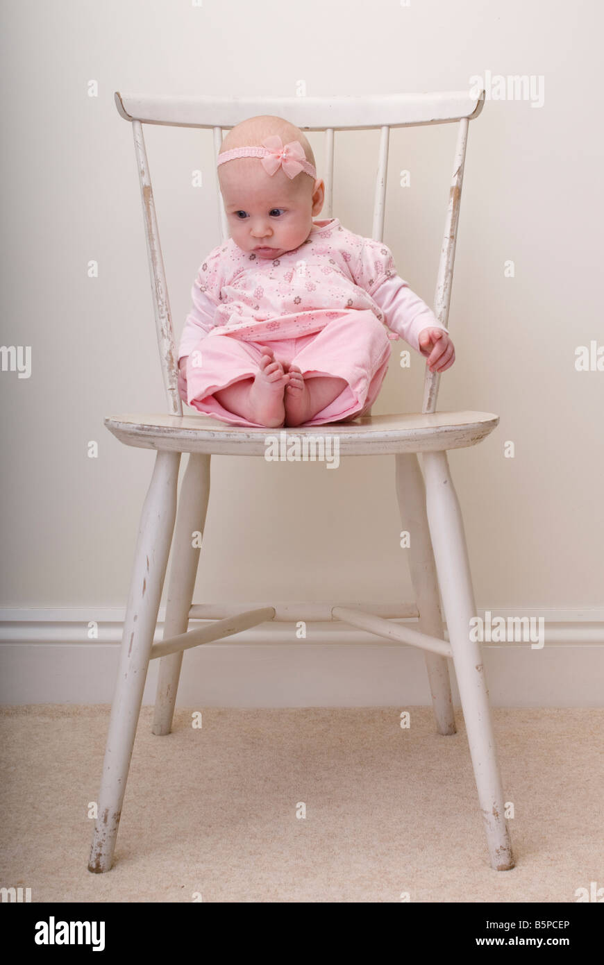 baby girl sitting on chair Stock Photo - Alamy