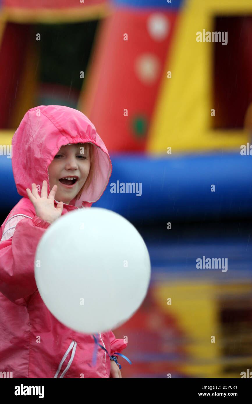A child playing with a balloon at a Fire Safety Fair in the rain Stock ...