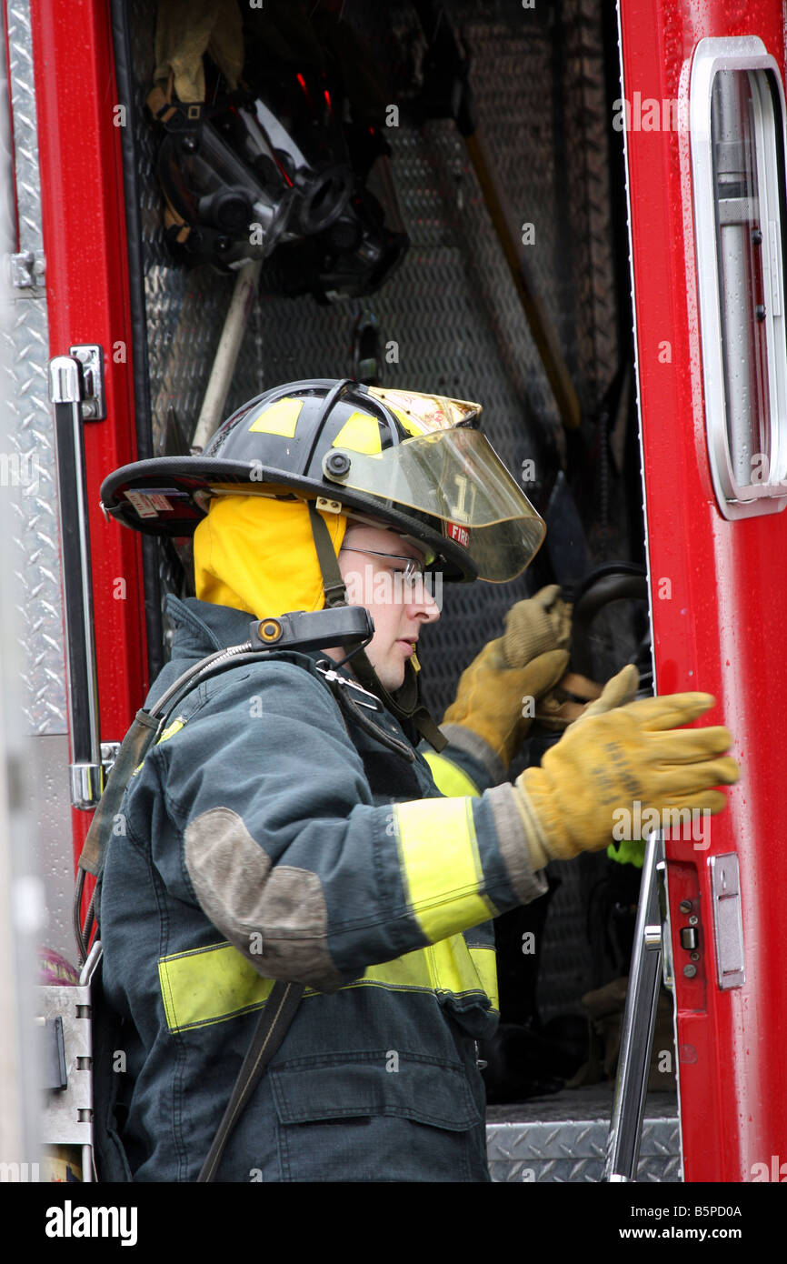A firefighter closing the cab door of a fire truck Stock Photo - Alamy