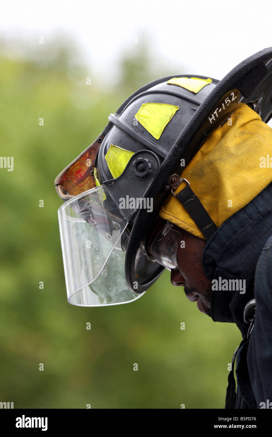 A firefighter looking down on a car during extrication Stock Photo - Alamy