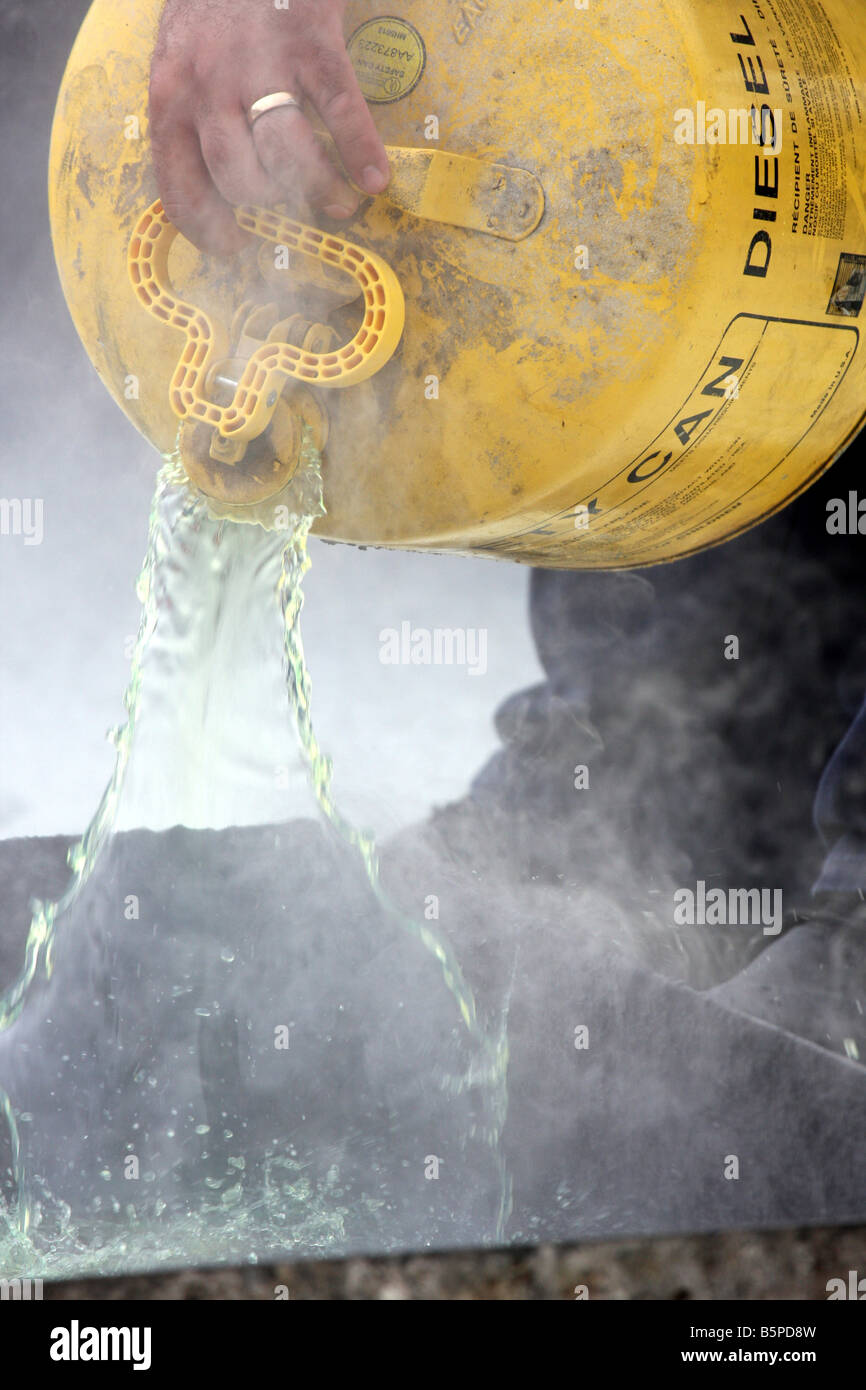 A person pouring diesel fuel on a fire display at a fire fair Stock ...