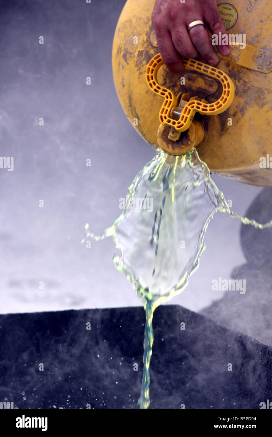 A person pouring diesel fuel on a fire display at a fire fair Stock ...