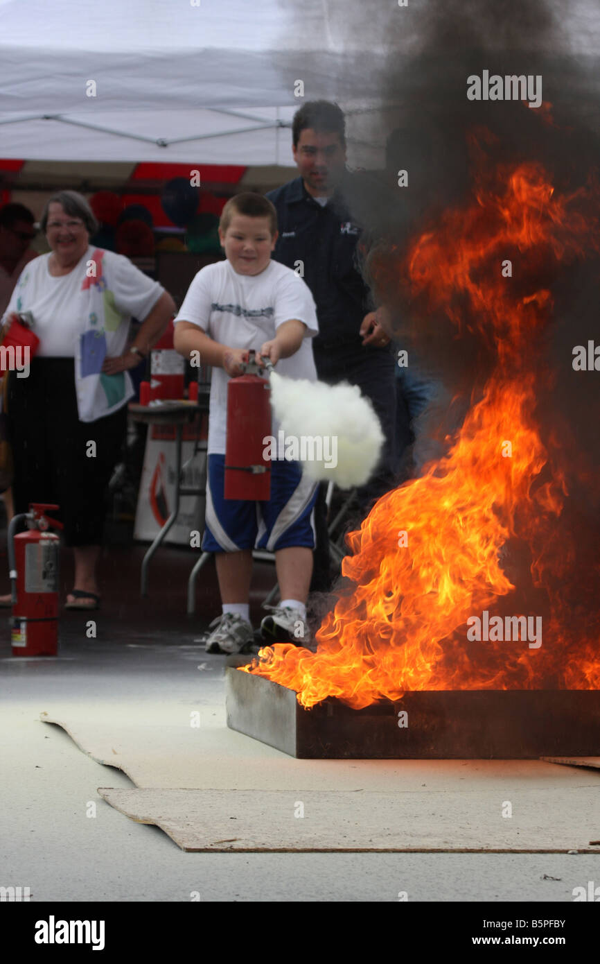 Child using a fire extinguisher to extinguish the flames on a display ...