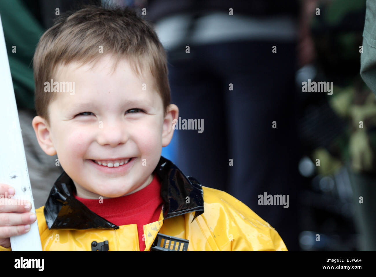 A young boy dressed in a yellow fire department rain jacket at a Fire ...
