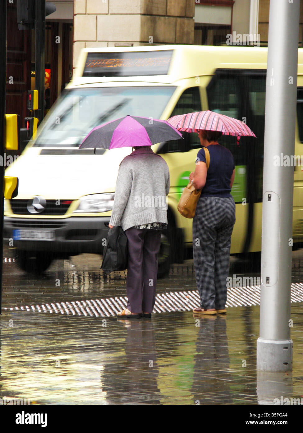 Waiting for the bus in the rain, umbrella x 2, up for protection ...