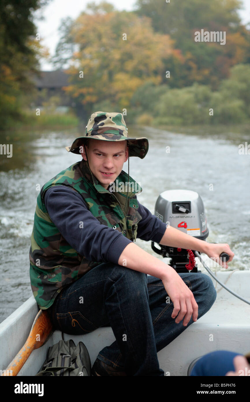 a teenage boy going out fishing in a motor-boat Stock Photo - Alamy