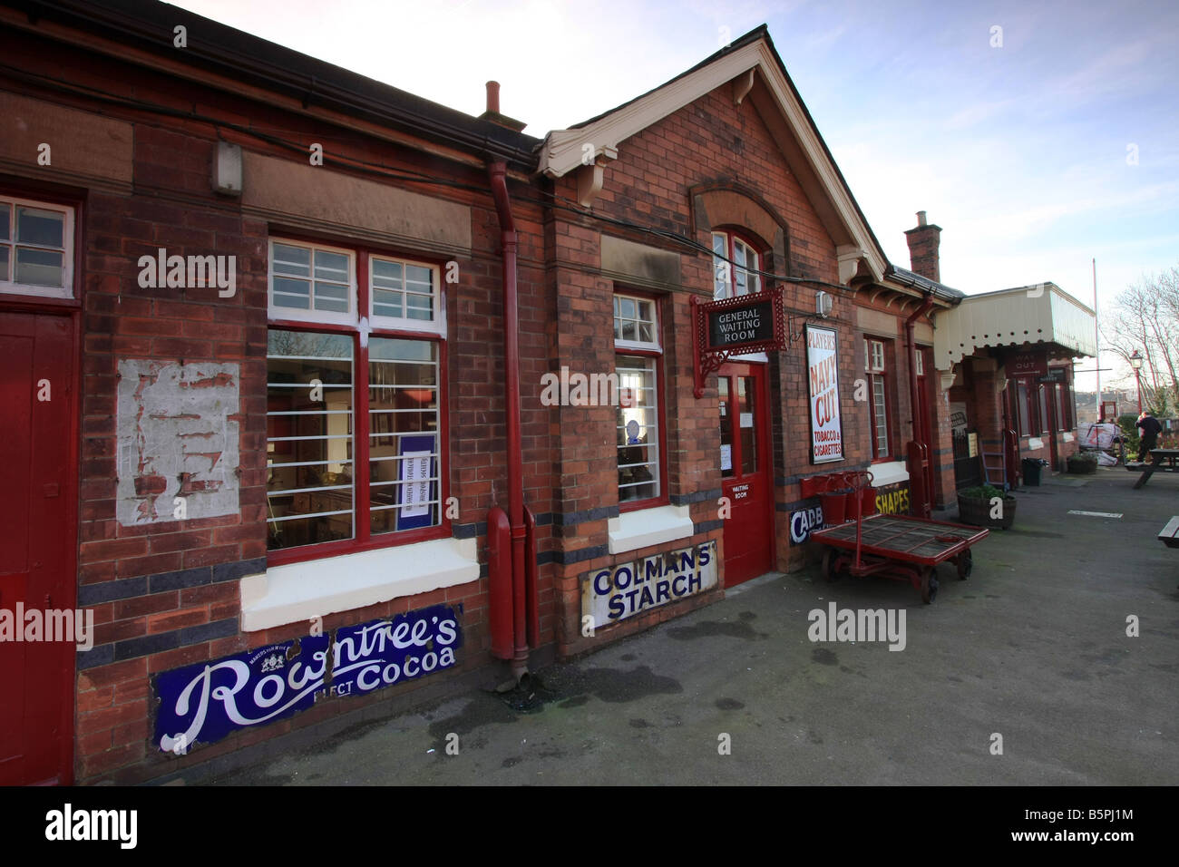 An old fashioned railway station platform with period advertising signs ...