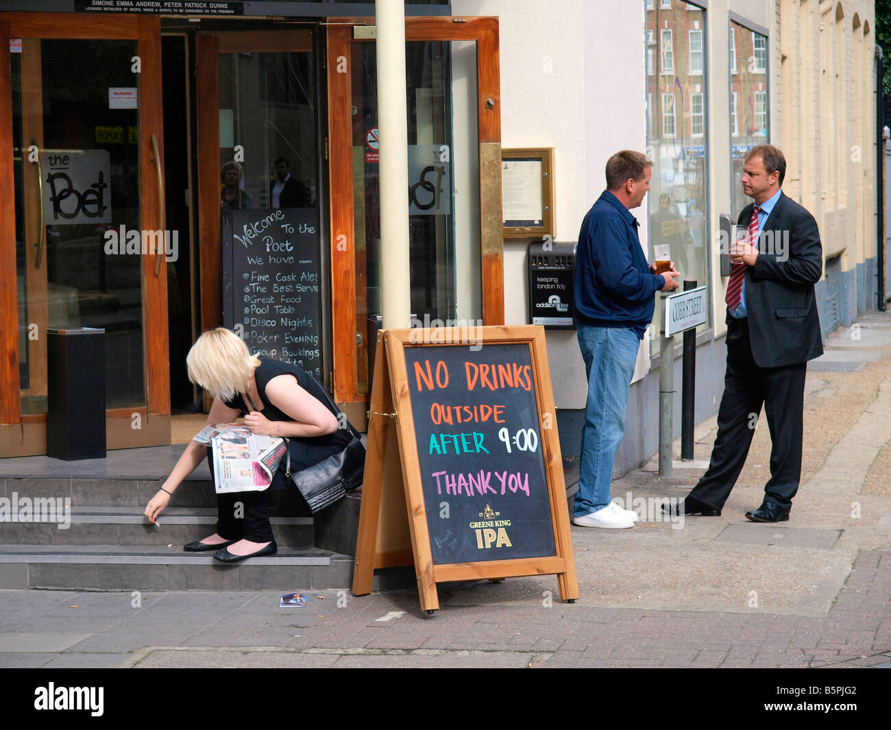 Two men drinking and a girl smoking outside of a pub London UK Stock ...