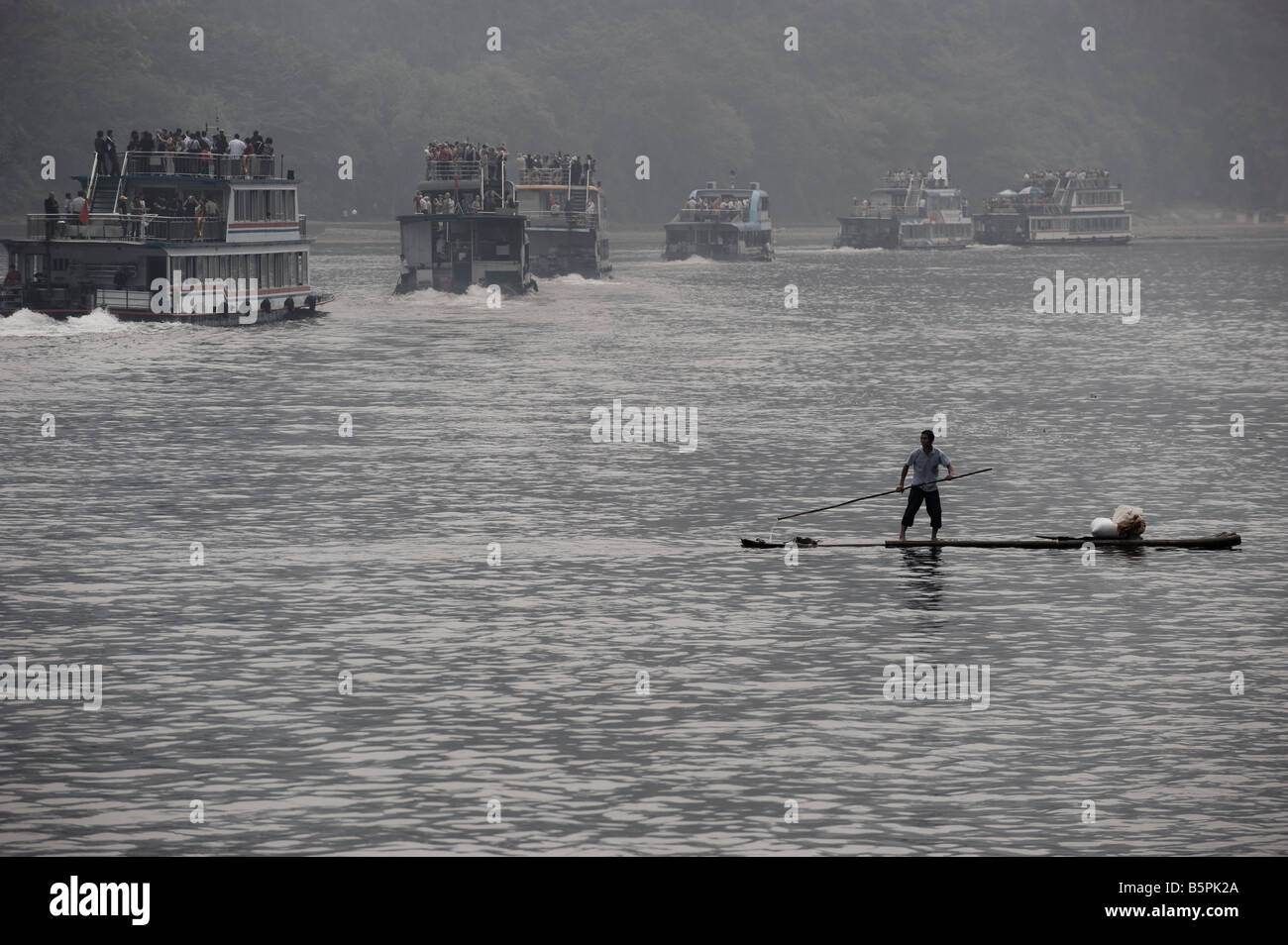Floating souvenir salesman on board bamboo raft close to tourist ...