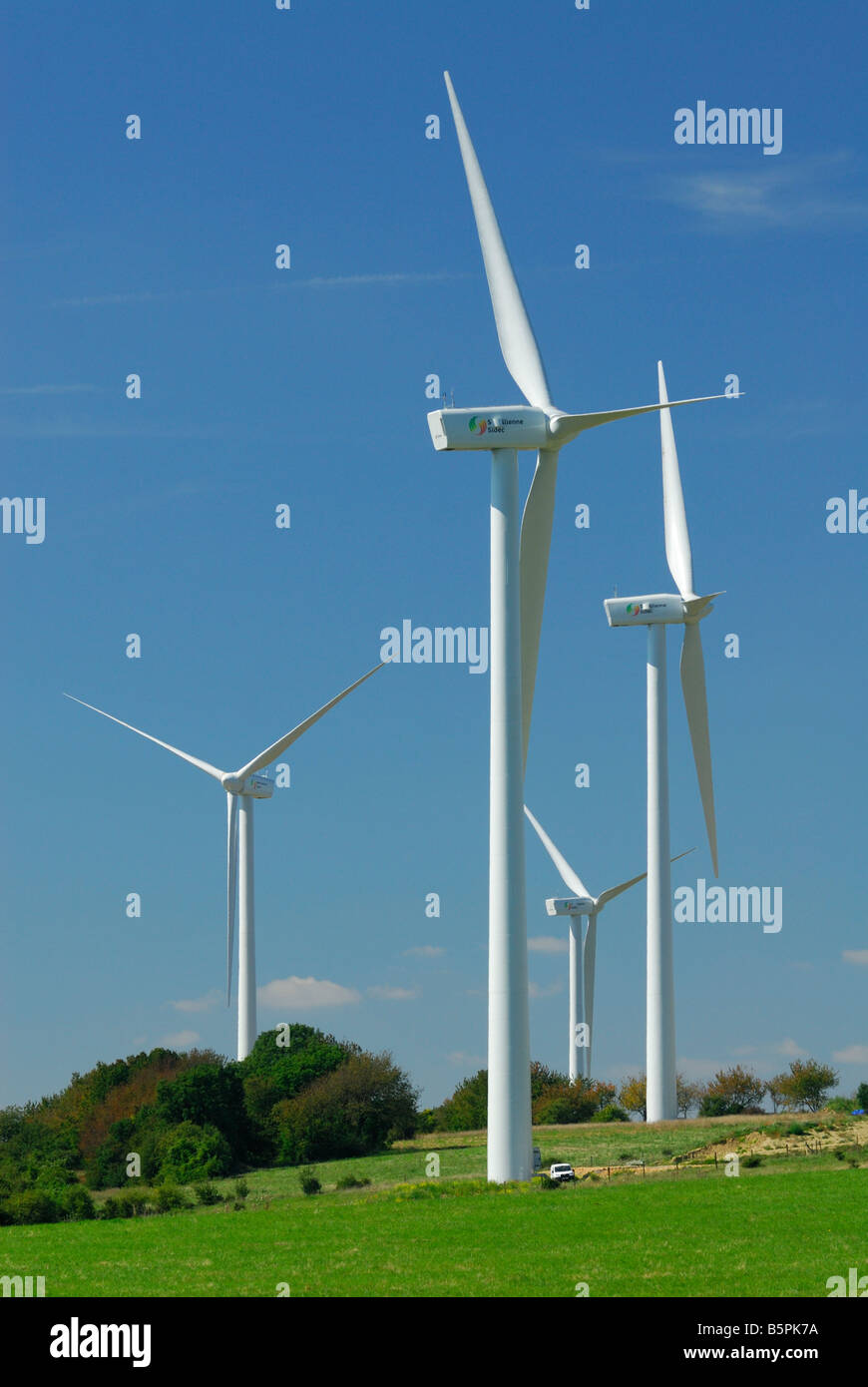 Four windturbines of wind farm on blue sky and green field - France ...