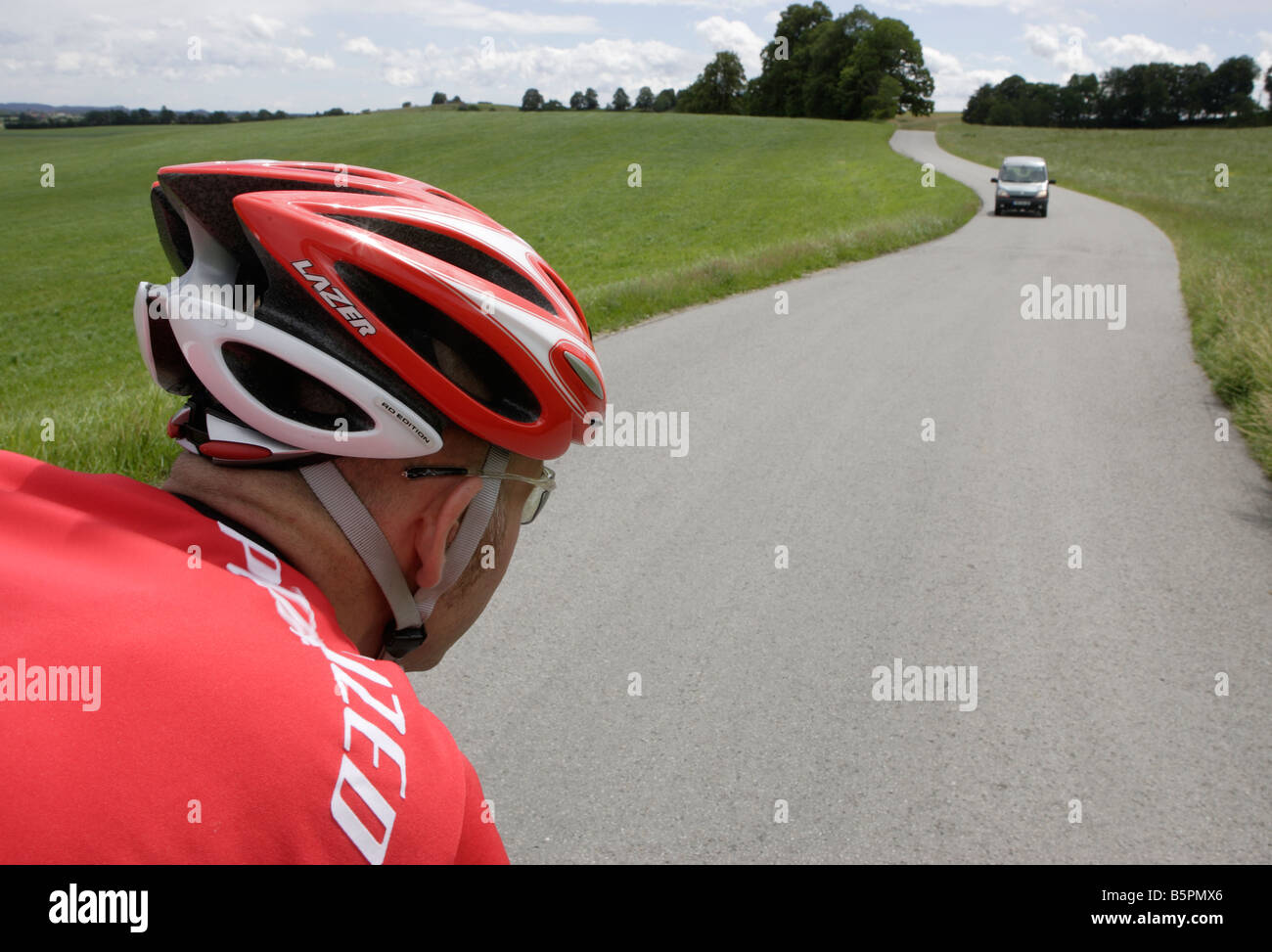 Car behind cyclist hi-res stock photography and images - Alamy