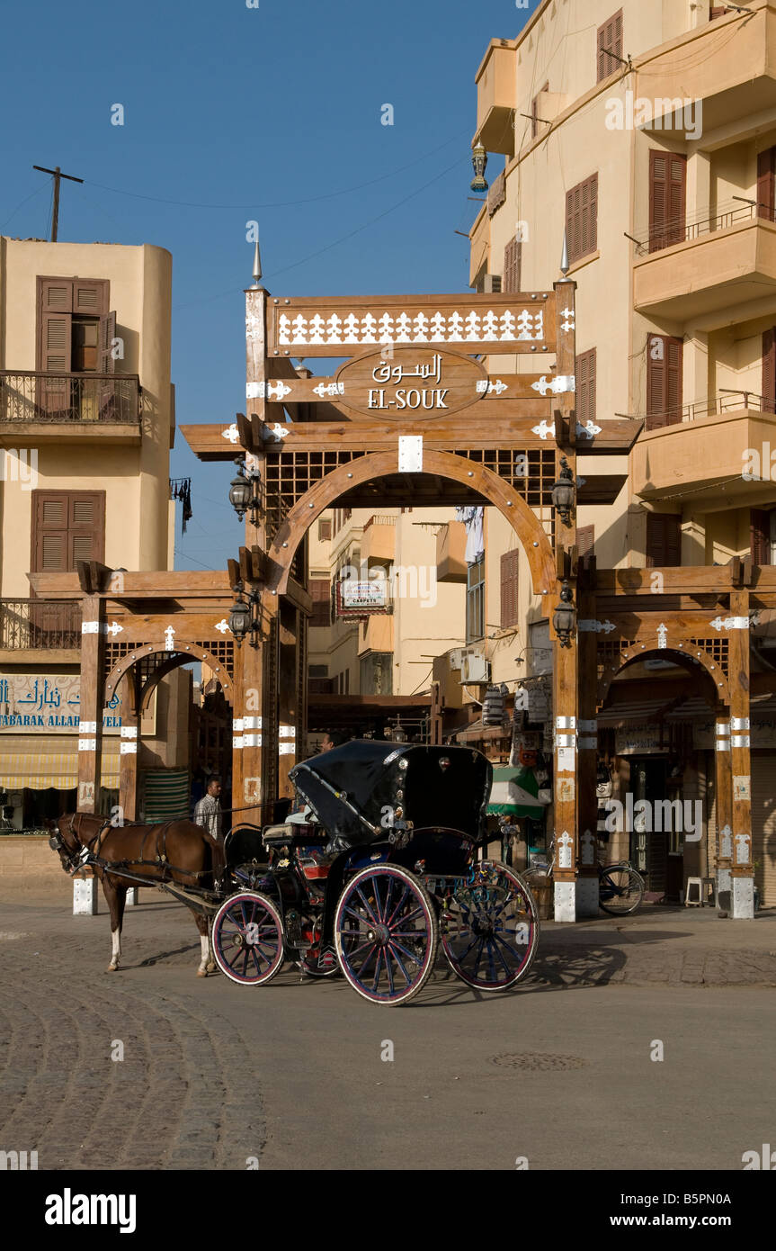 A Caleche horse drawn carriage passes by the entrance to the El Souk ...