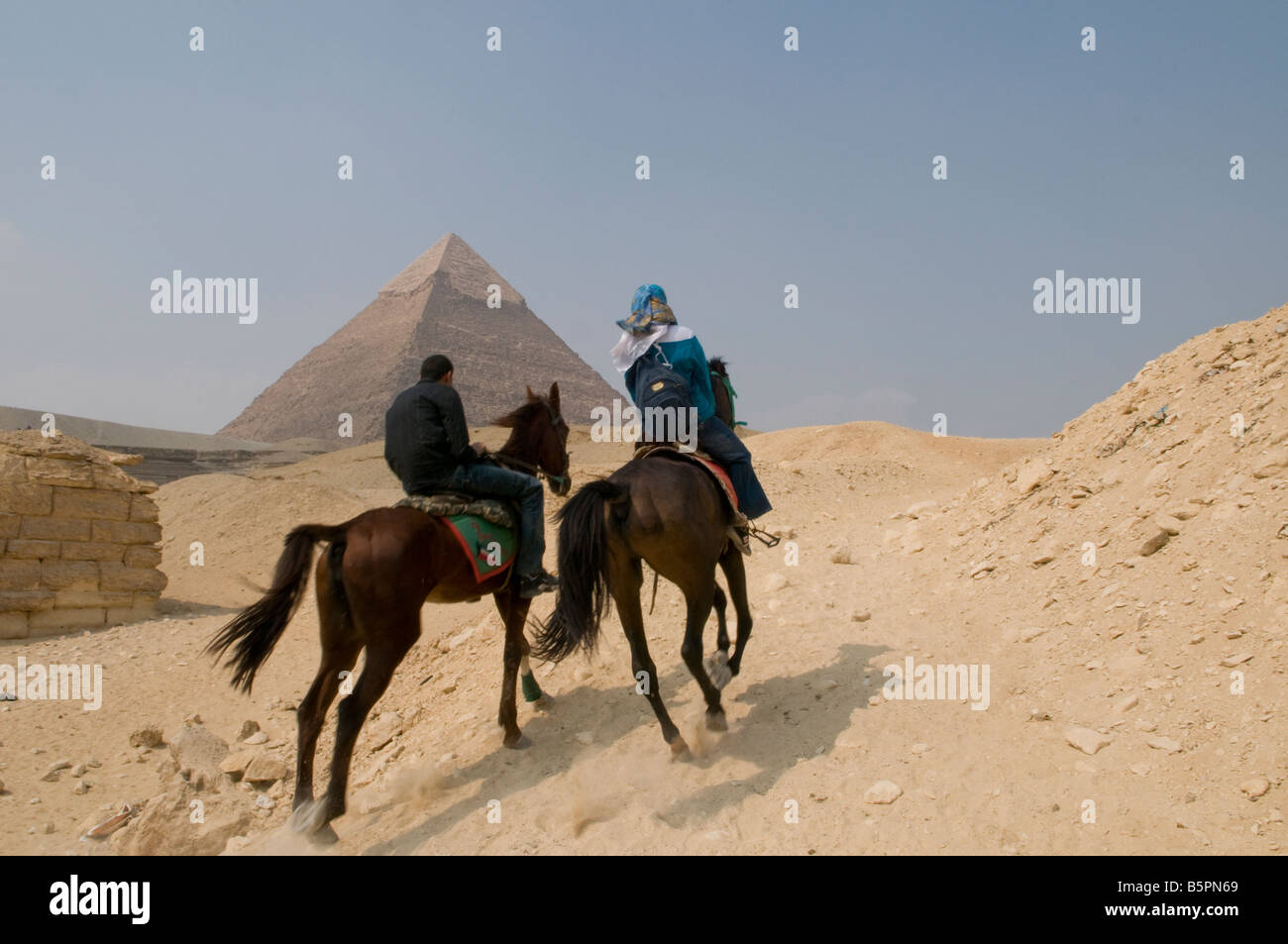A tourist and her guide riding horse around Pyramid of Khafre at the ...