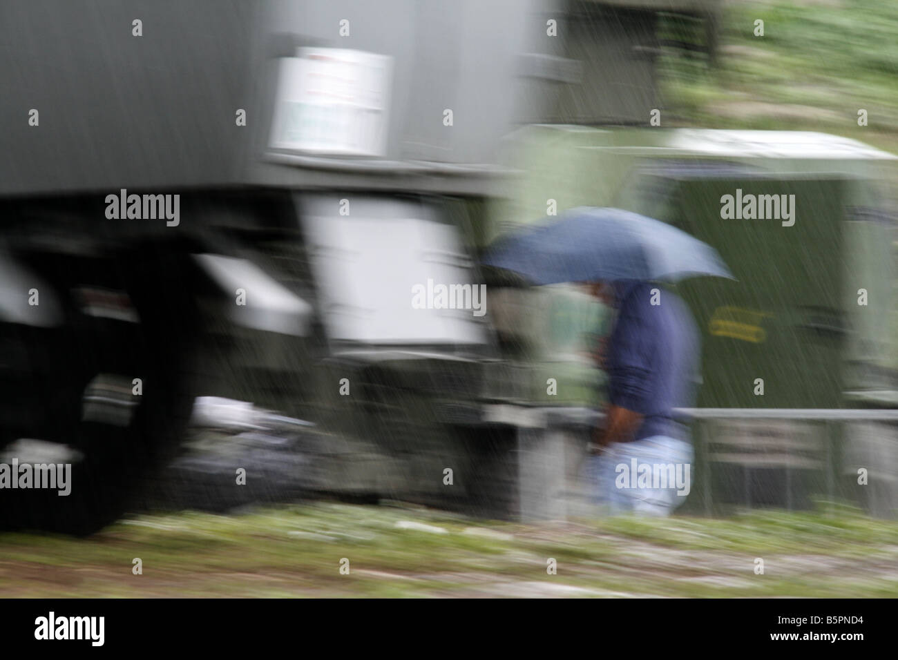 person with umbrella walking in rain in field Stock Photo - Alamy