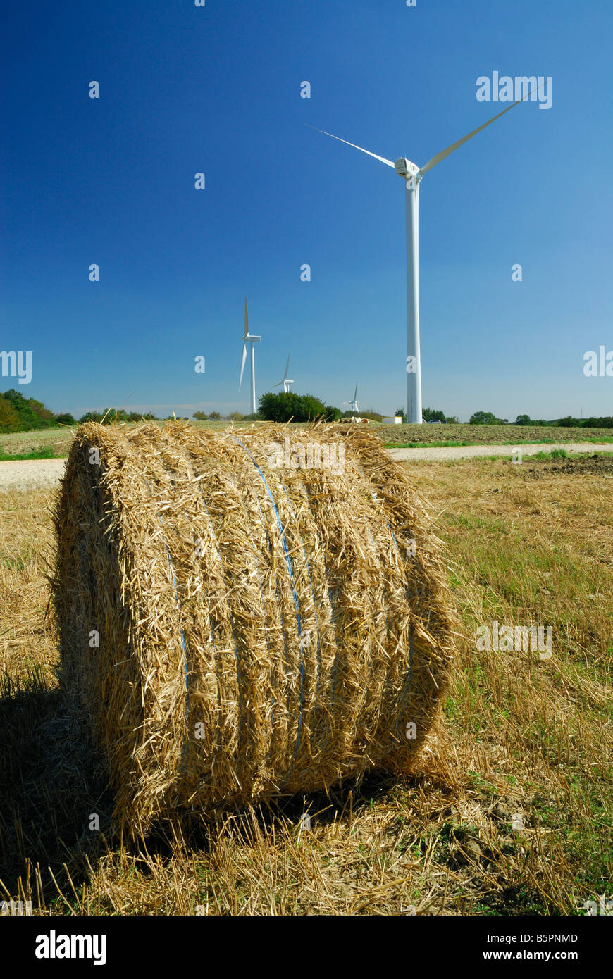 Wind turbine in an harvest meadow with hay bales, Lorraine region ...