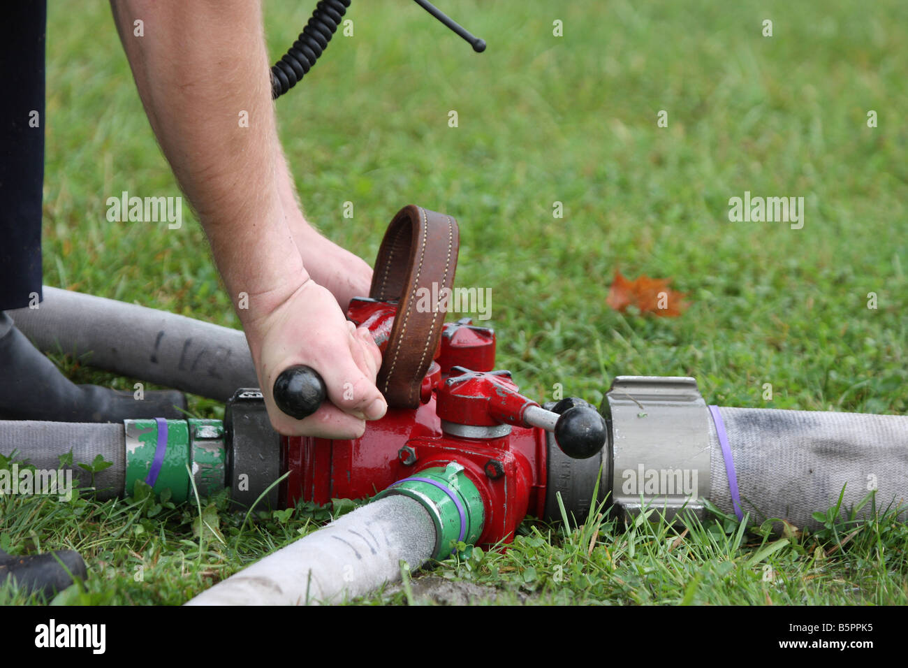 firefighter turning off the valves to supply multiple hose lines with ...