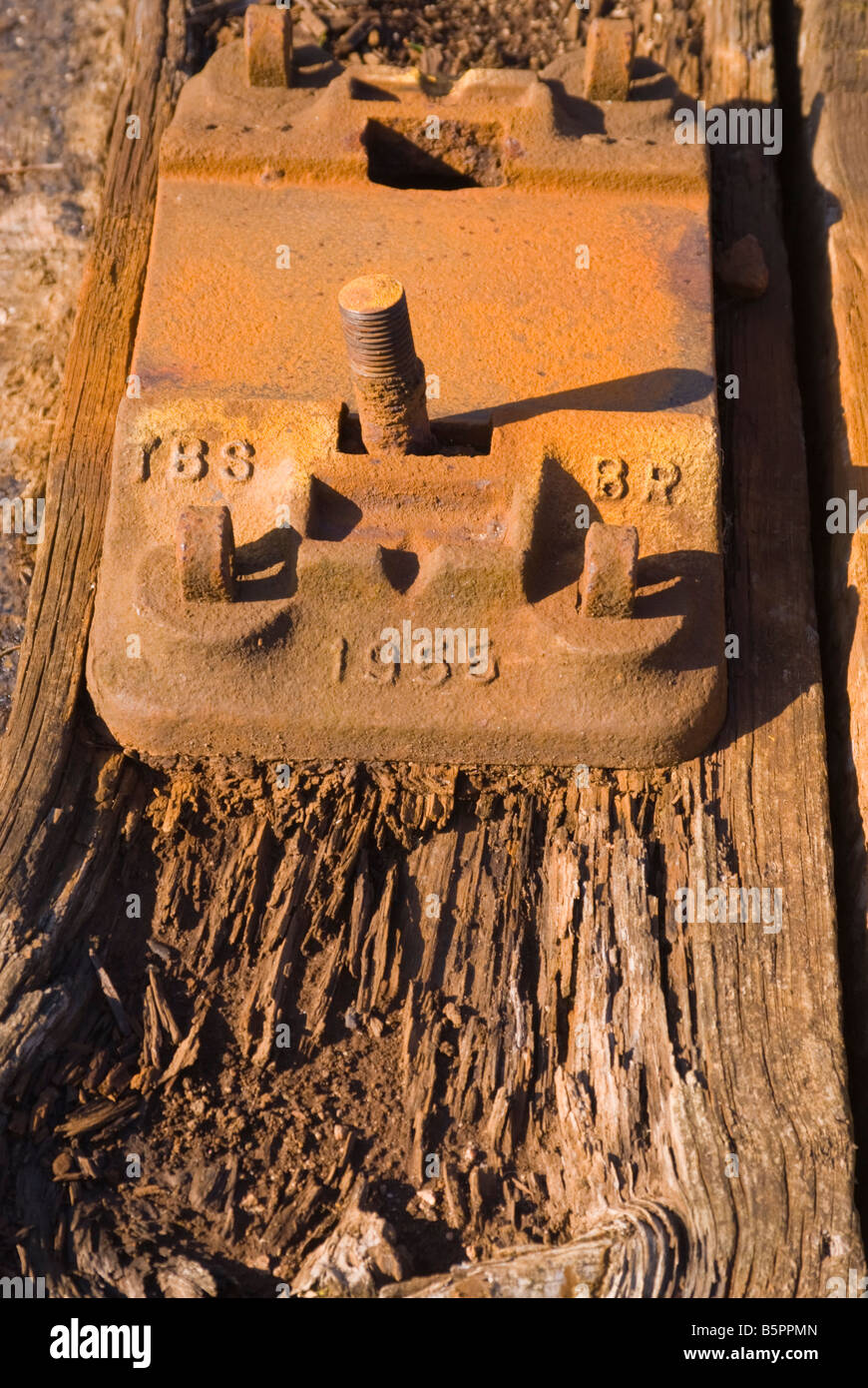 Close up of metal fixing block on british rail train track sleeper ...