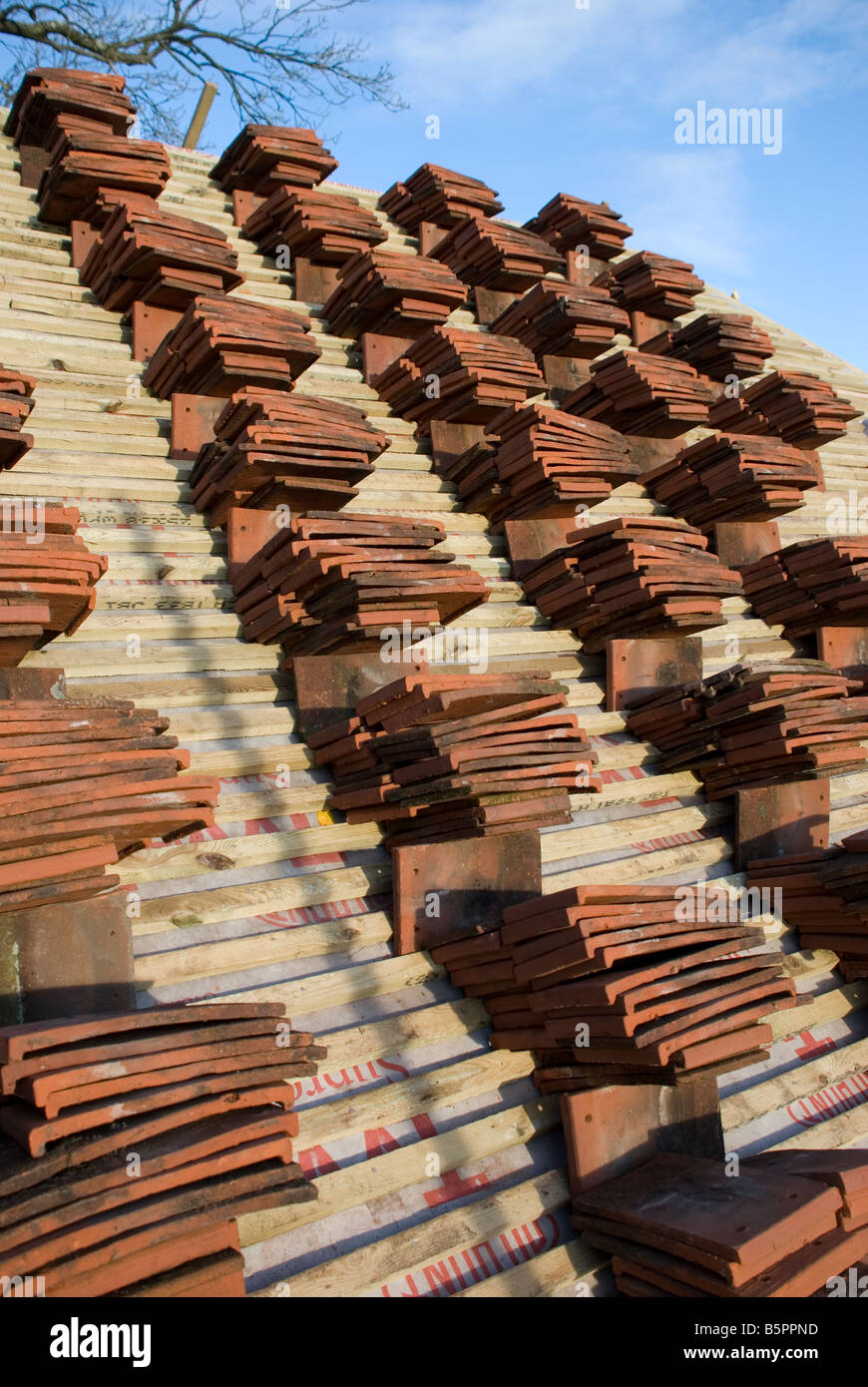 Clay roof tiles stacked on a barn roof ready to be laid on the new ...
