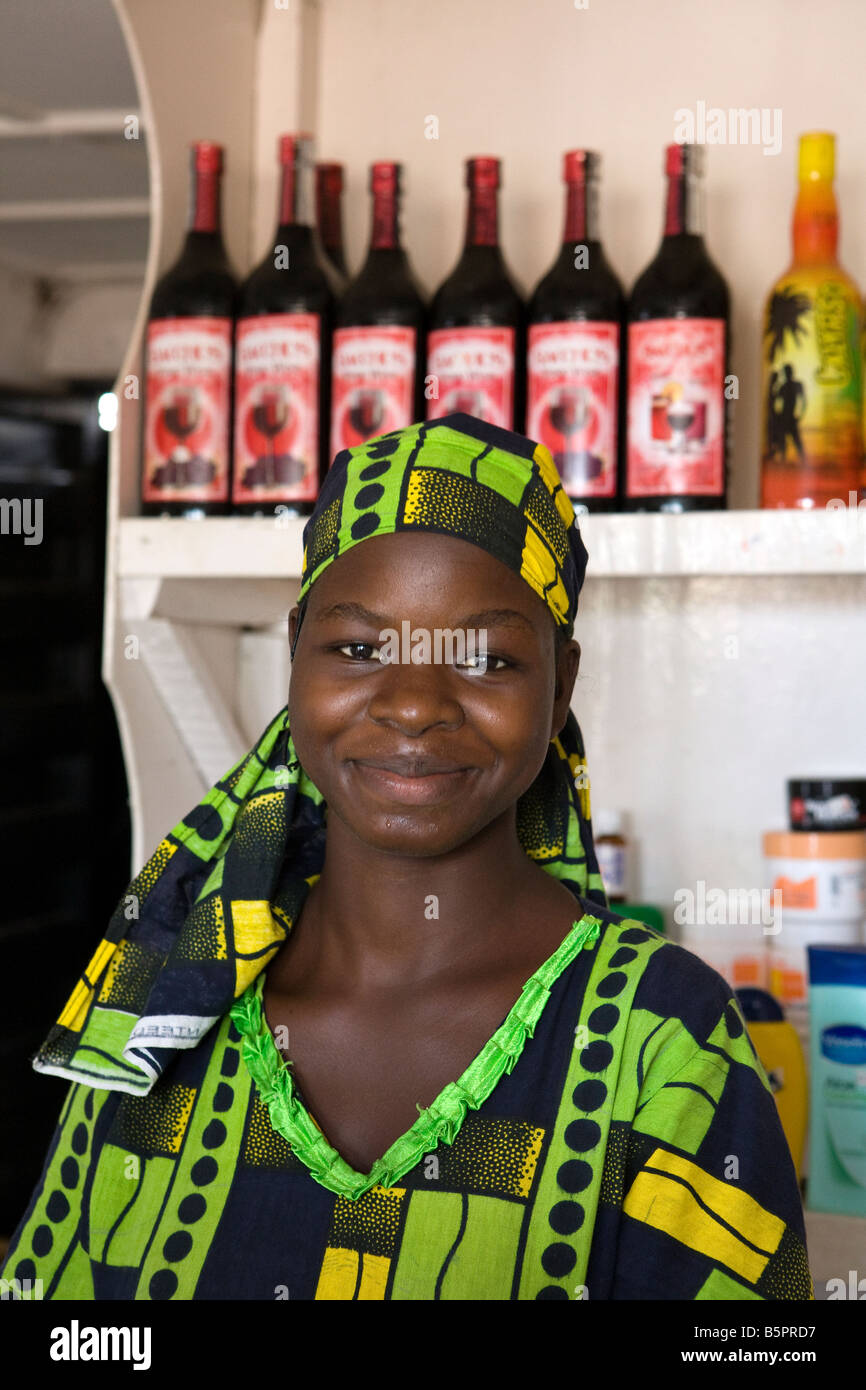 A Nigerian female shopkeeper poses for a picture in front of shelves ...