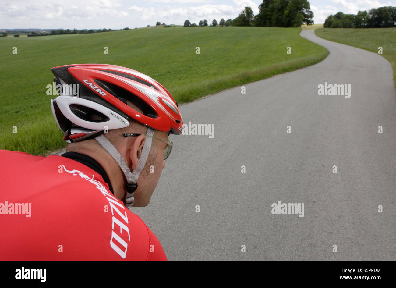 Racing cyclist wearing a helmet looking at the street ahead of him ...
