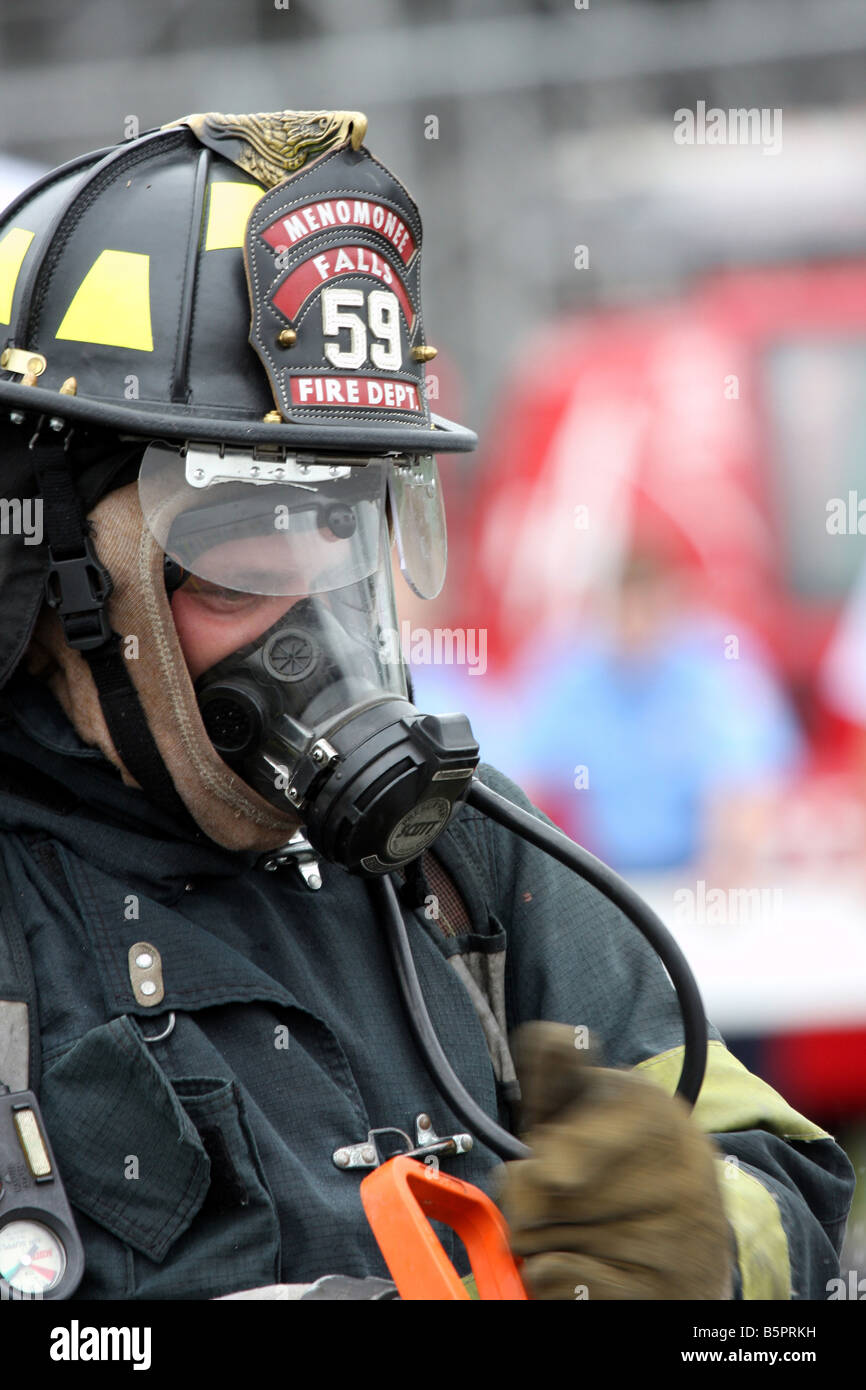A firefighter ready with a hoseline nozzle to fight a fire Stock Photo ...