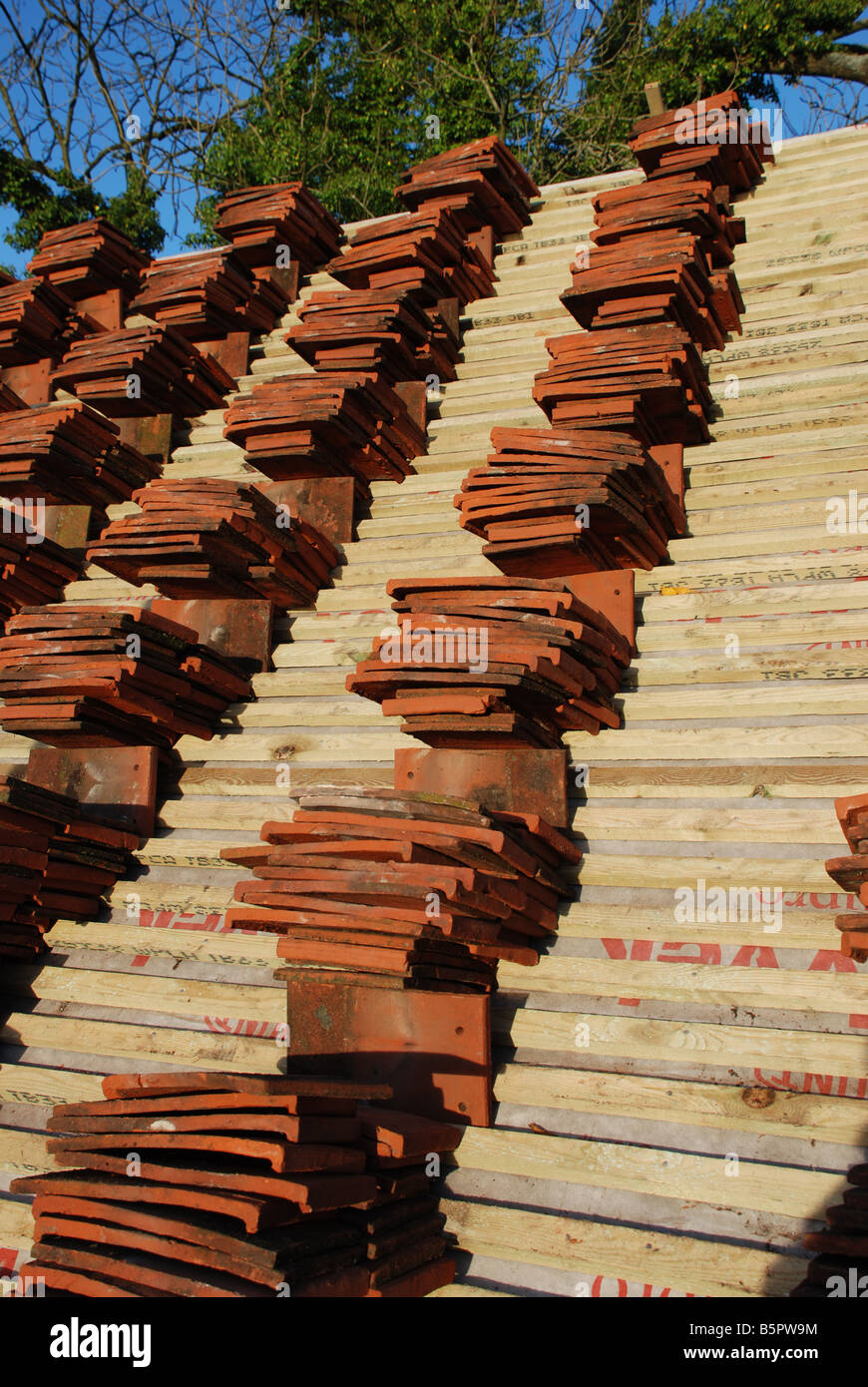 Clay roof tiles stacked on a barn roof ready to be laid on the new ...