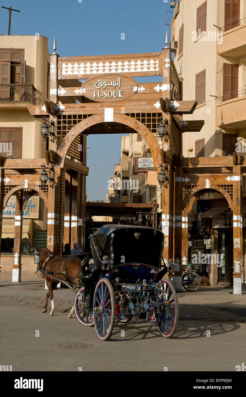 A Caleche horse drawn carriage passes by the entrance to the El Souk ...
