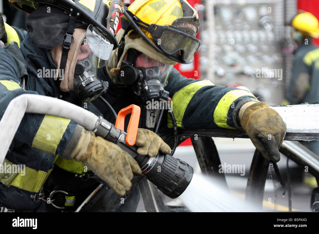 Three firefighters puting out a car fire Stock Photo - Alamy