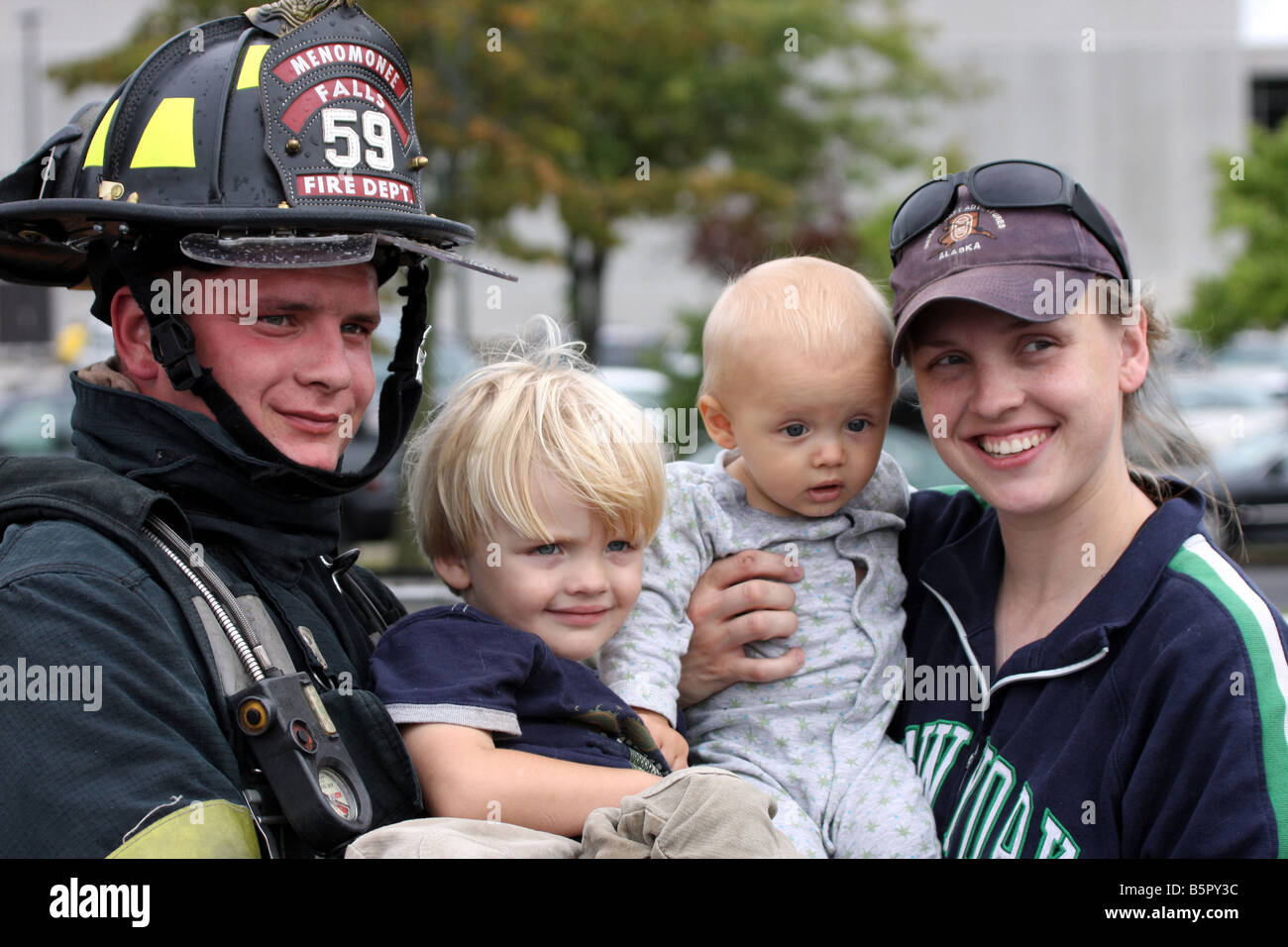 A family pose with a firefighter Stock Photo - Alamy