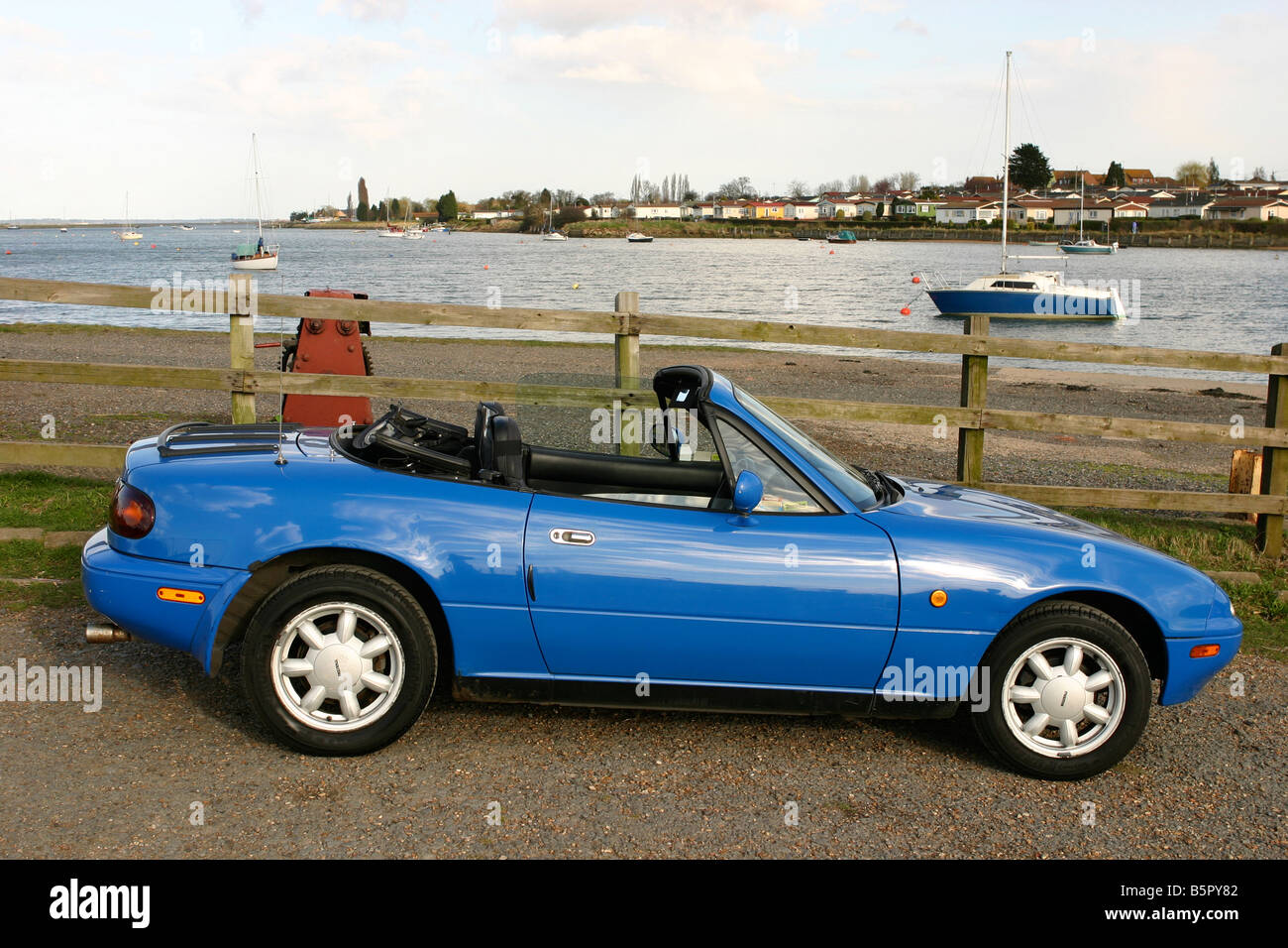 Mazda MX5 Mk1 2 seater sports car with roof down. Riverside setting ...