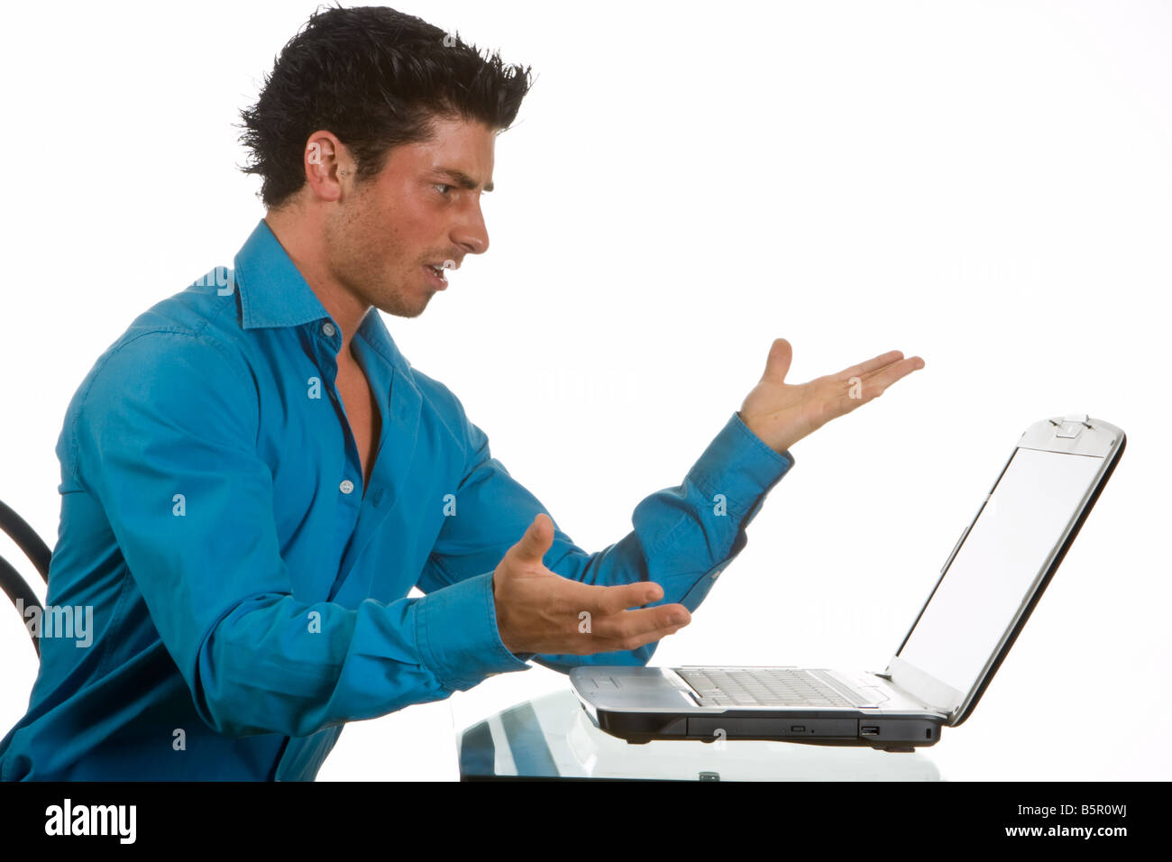 Attractive young man looking upset at his laptop Stock Photo - Alamy