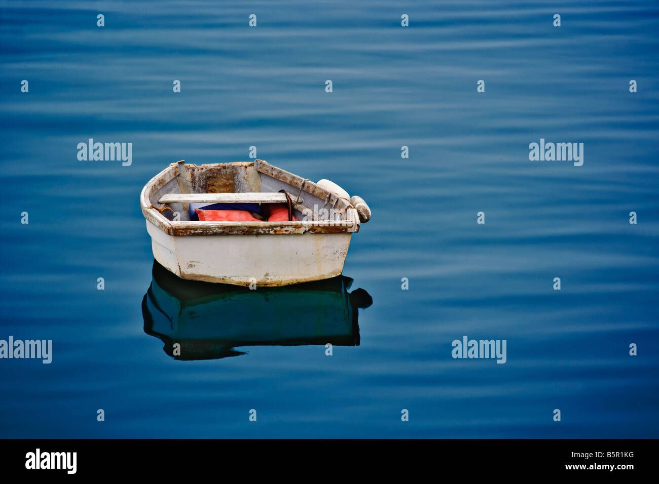 Single small boat floating on ocean Maine Stock Photo - Alamy