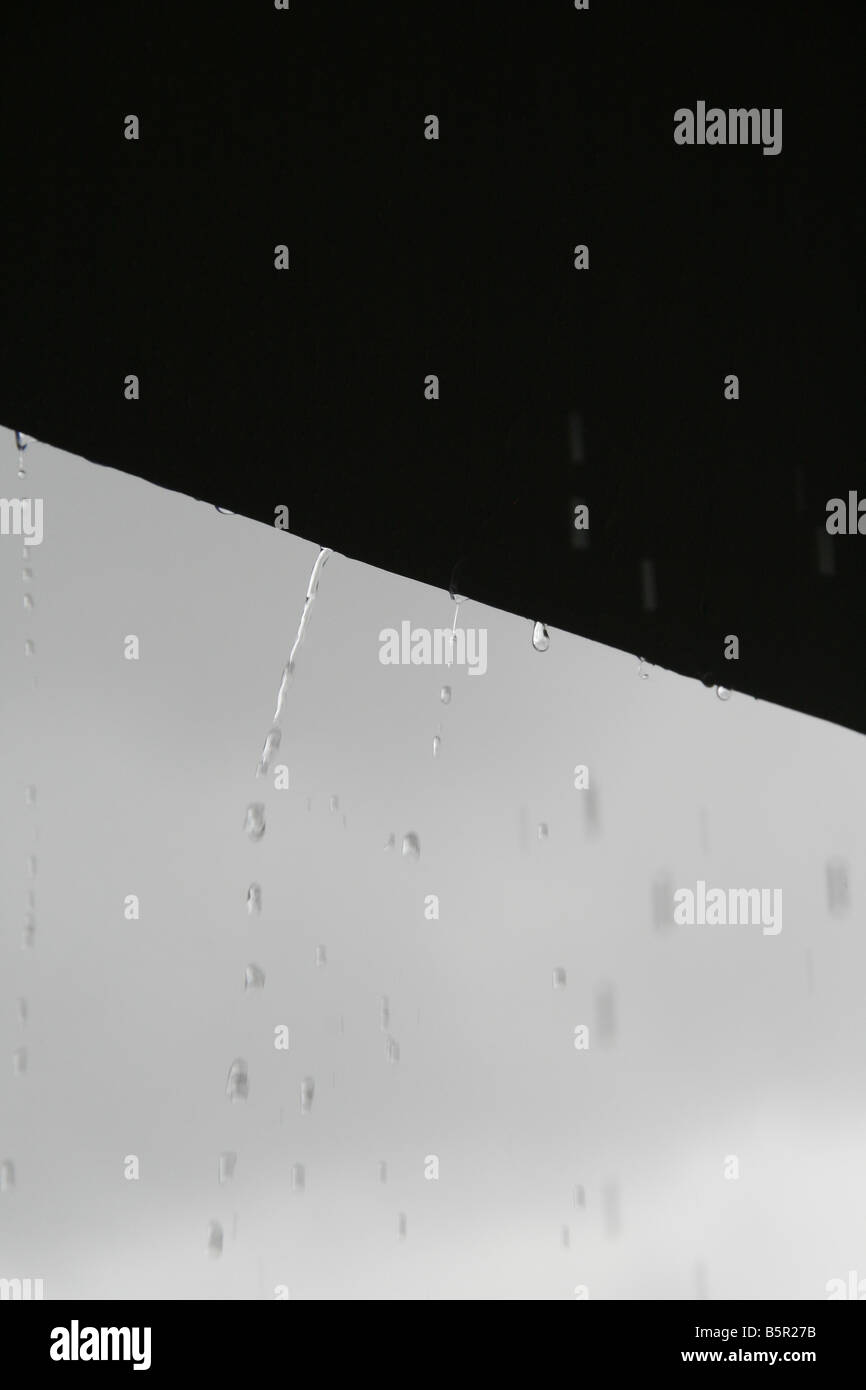 lots rain drops falling off property roof Stock Photo - Alamy