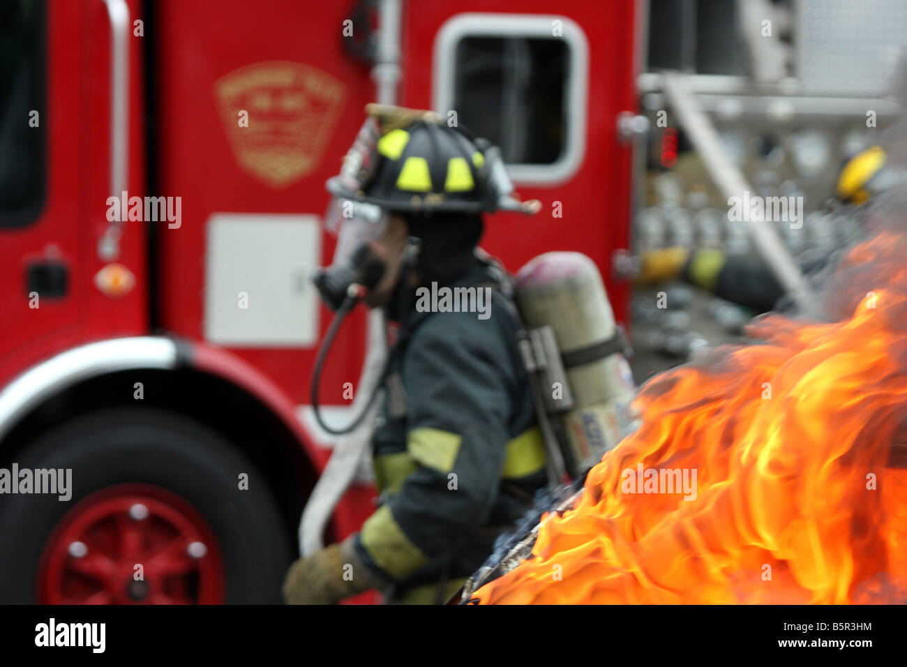 A firefighter getting a hoseline ready at a fire demonstration at a ...