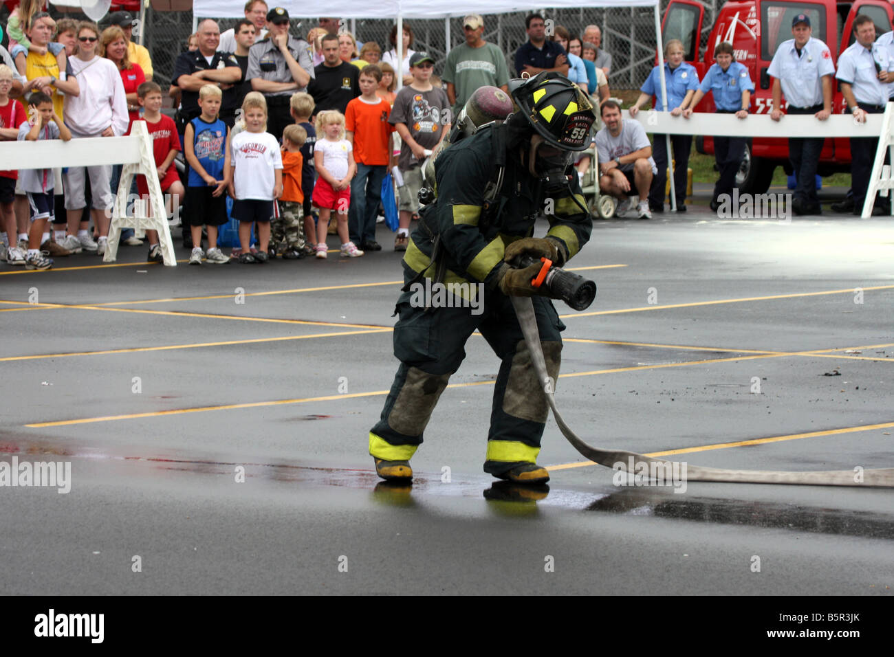 A firefighter getting a hoseline ready at a demonstration at a Fire ...