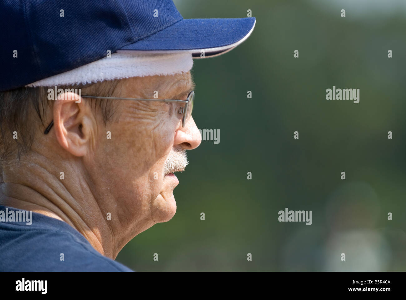 65 year old man watches intently as his softball team plays the game ...