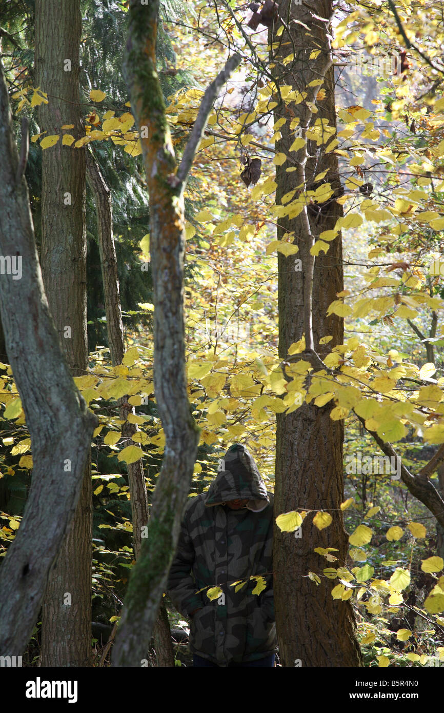 Man in wood wearing camouflage jacket Stock Photo - Alamy