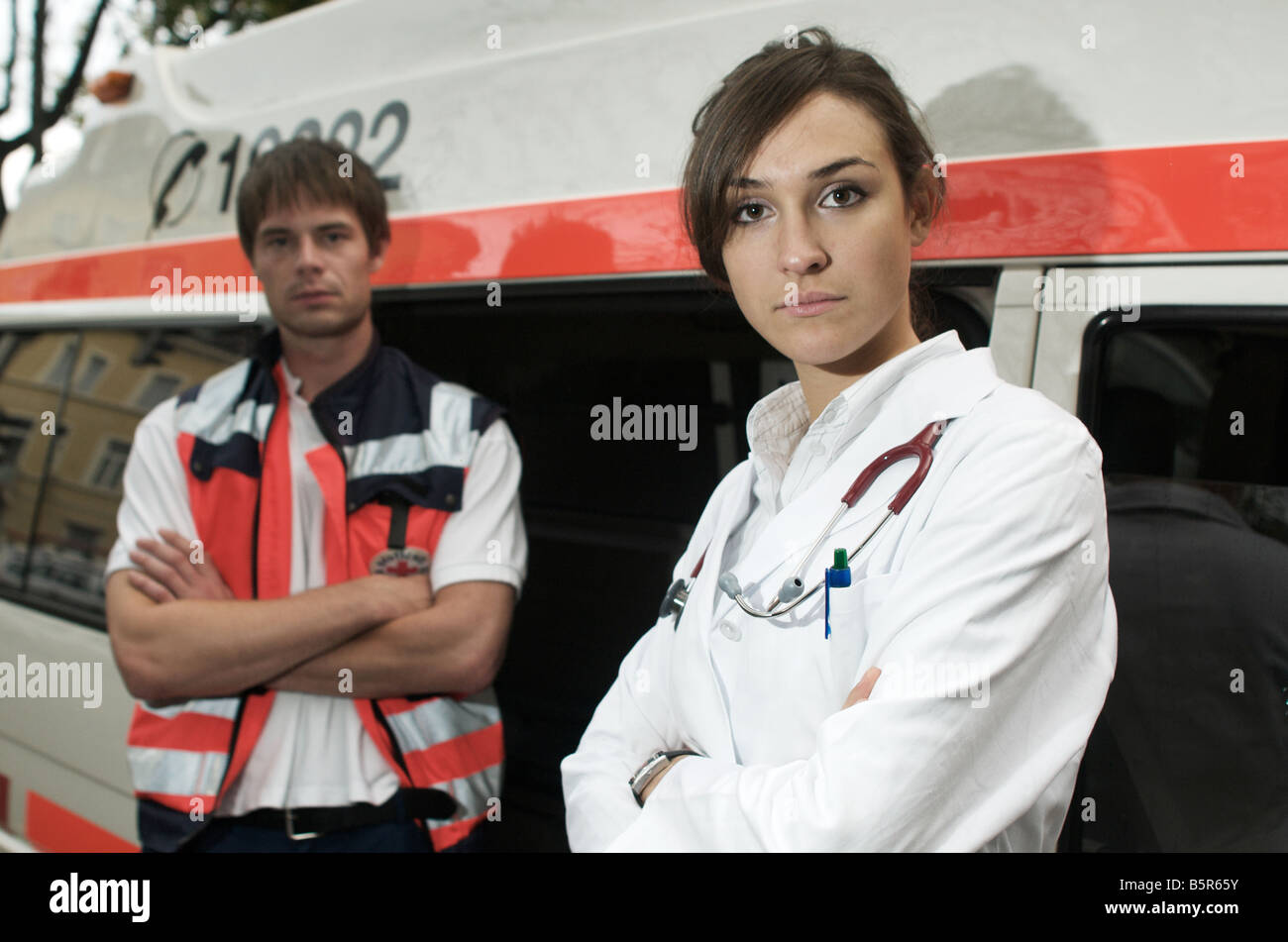 Young doctor and paramedic standing by an ambulance Stock Photo - Alamy